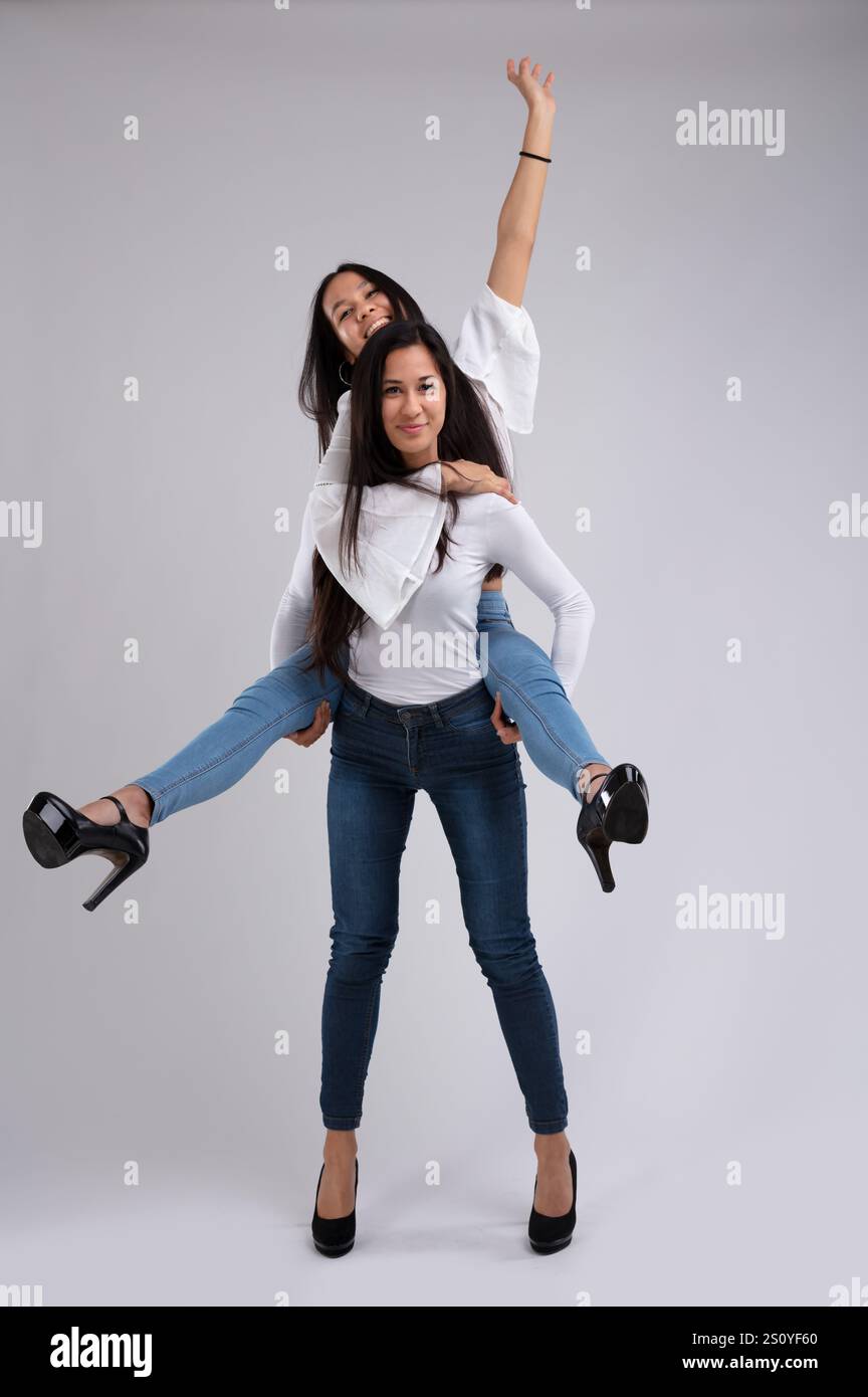 Young women enjoying a playful moment in a studio, giving each other ...