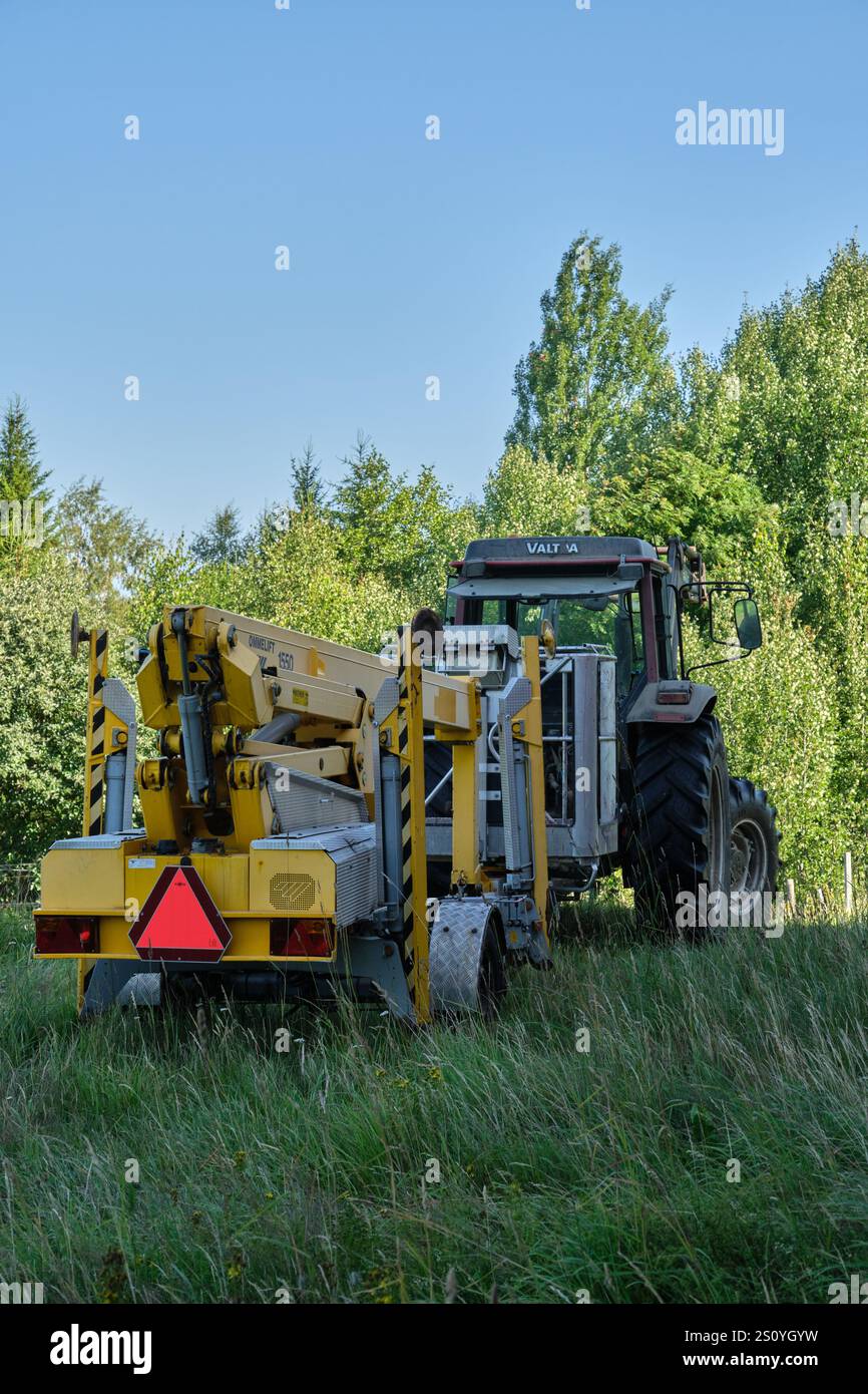 Tractor with lifting platform on the trailer hitch Stock Photo - Alamy