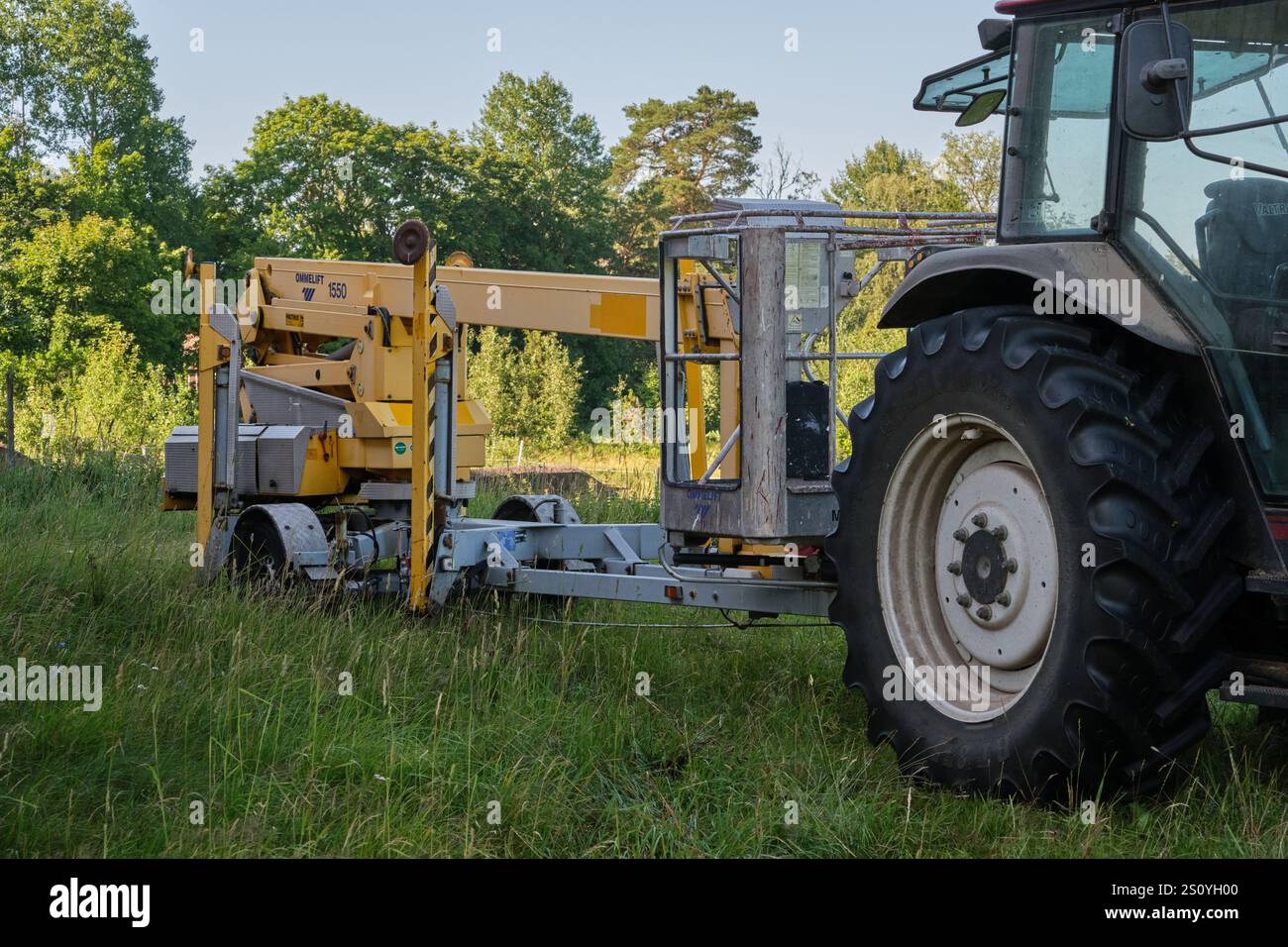 Tractor with lifting platform on the trailer hitch Stock Photo - Alamy