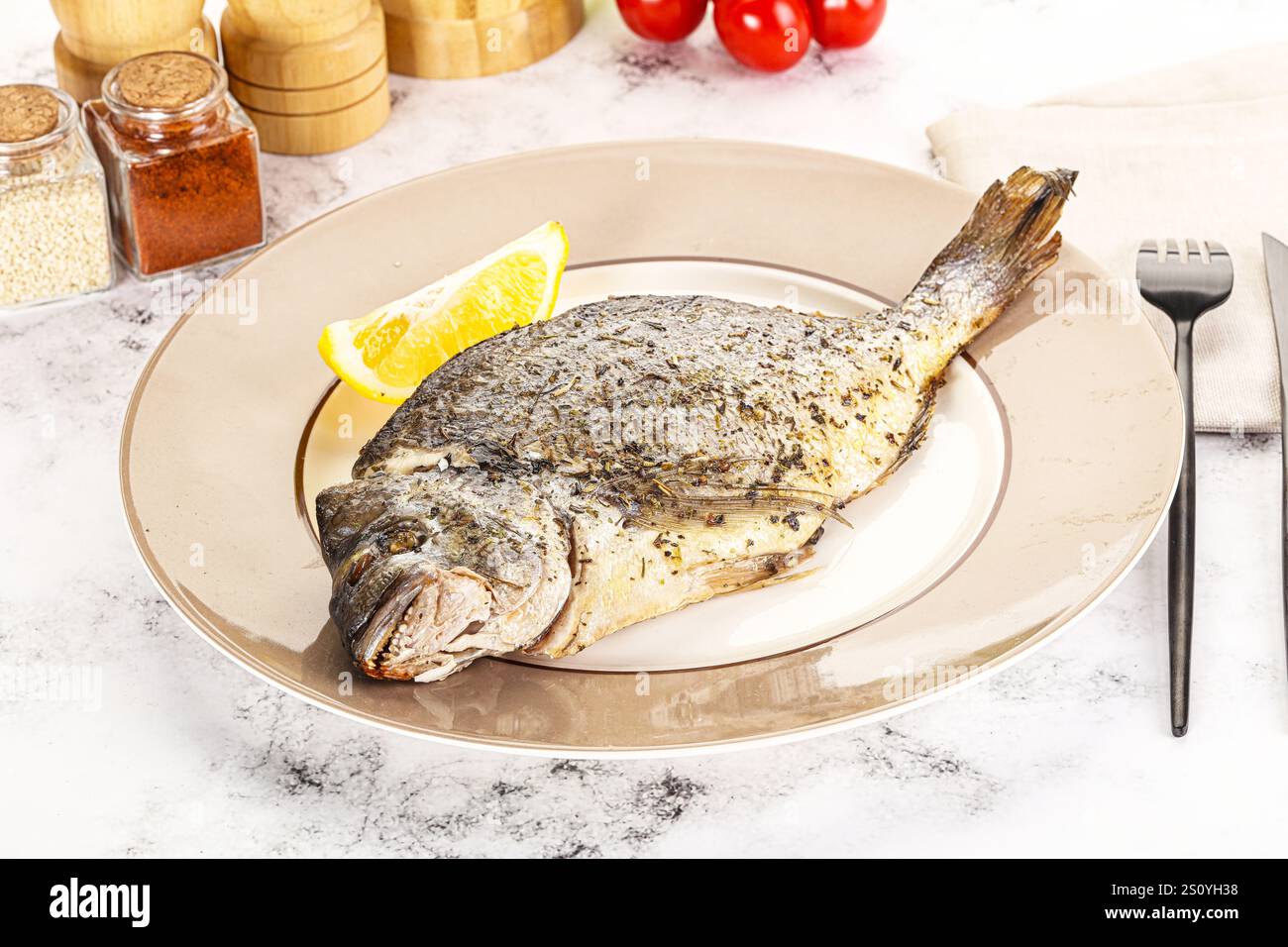 Baked Dorado fish served lemon slice Stock Photo - Alamy
