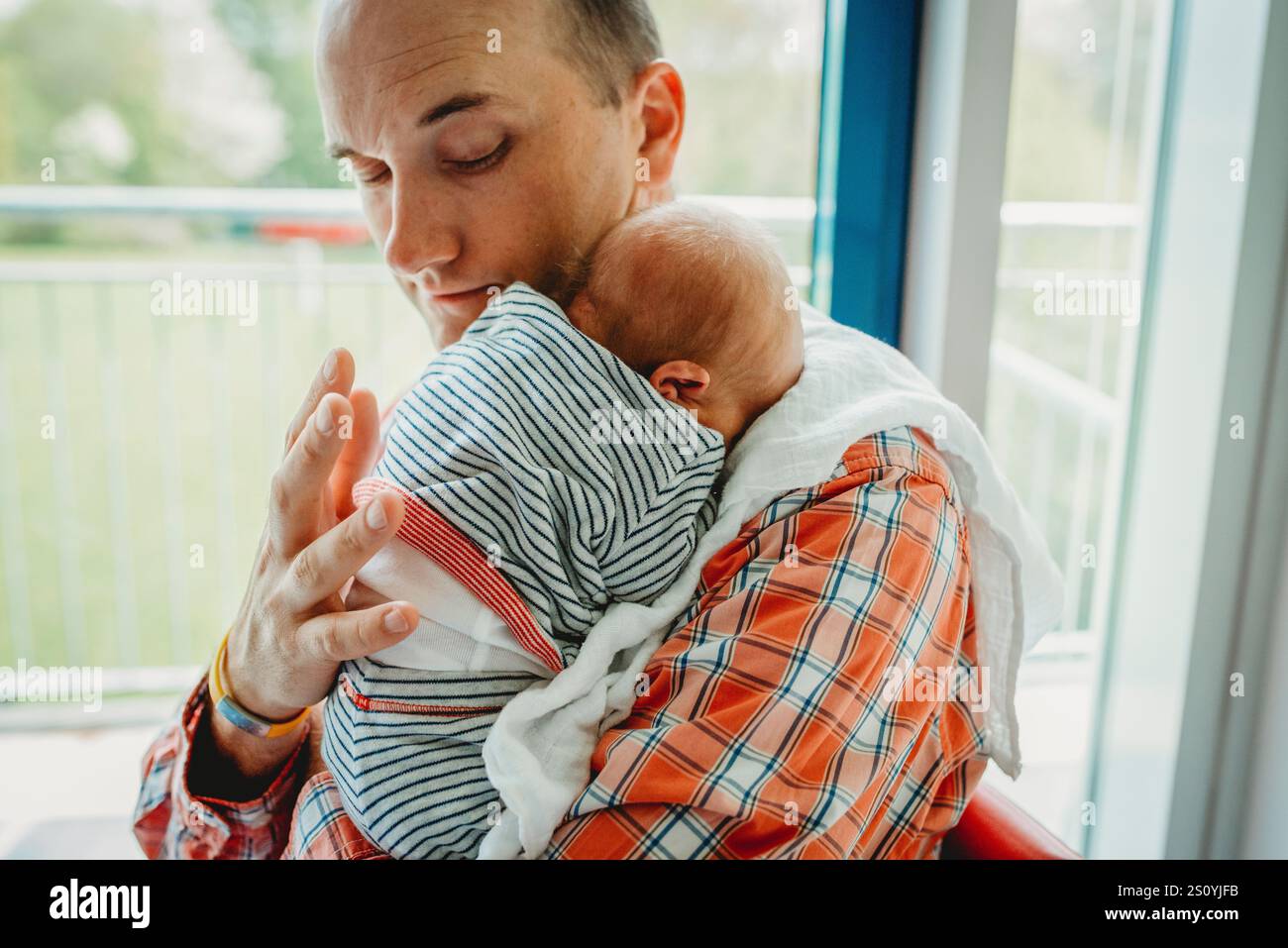 Father holding newborn baby sleeping at hospital burping Stock Photo ...
