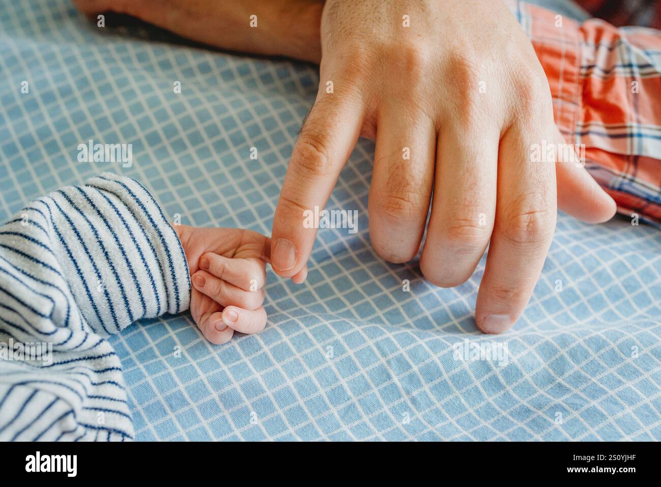 Newborn baby hand holding dad hand pinky fingers Stock Photo - Alamy