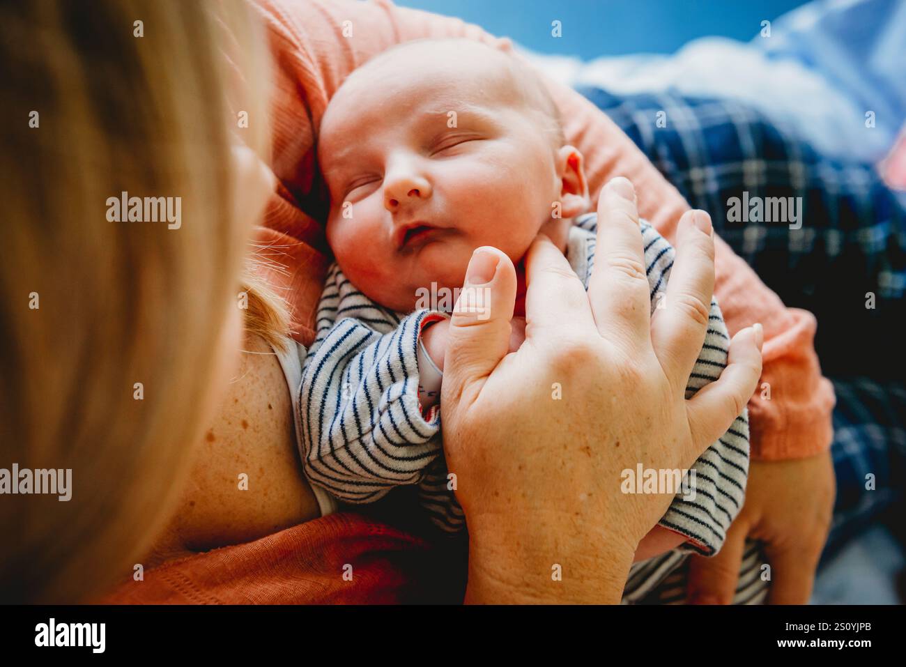 Newborn baby boy sleeping on mom arm at hospital after birth Stock ...