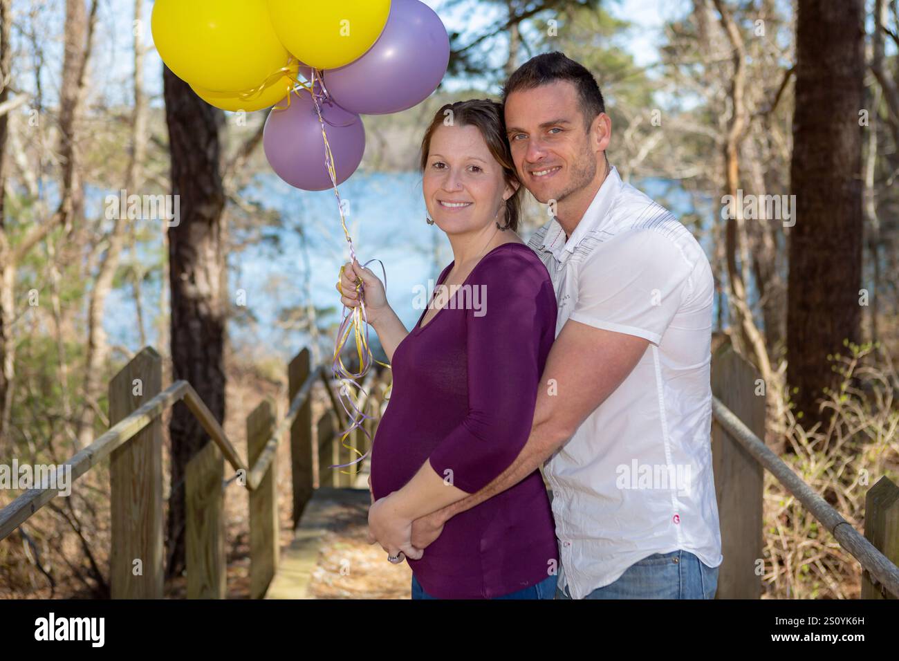 Soon to be father wraps his arms around his pregnant wifes belly Stock ...