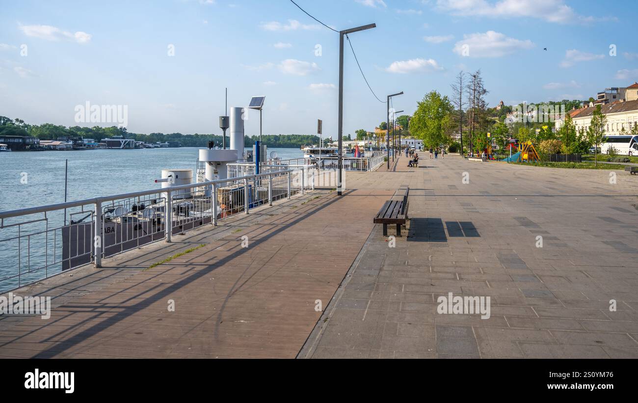 People enjoy a leisurely walk on the Sava Promenade, with the river and ...