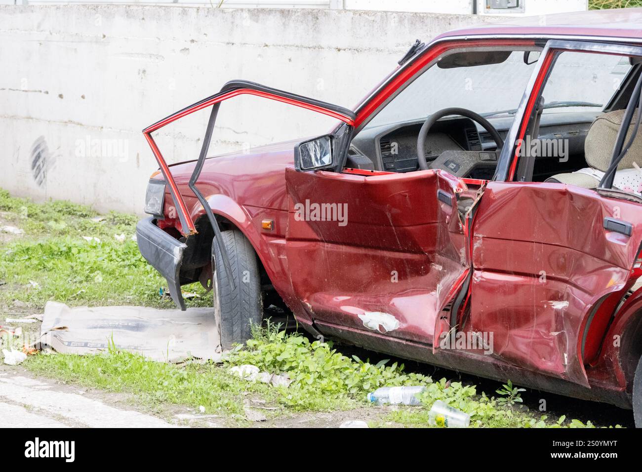 Red car with extensive damage from an accident, highlighting the ...