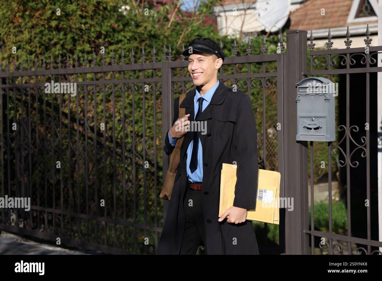 Happy postman with parcels outdoors. Mail service Stock Photo - Alamy