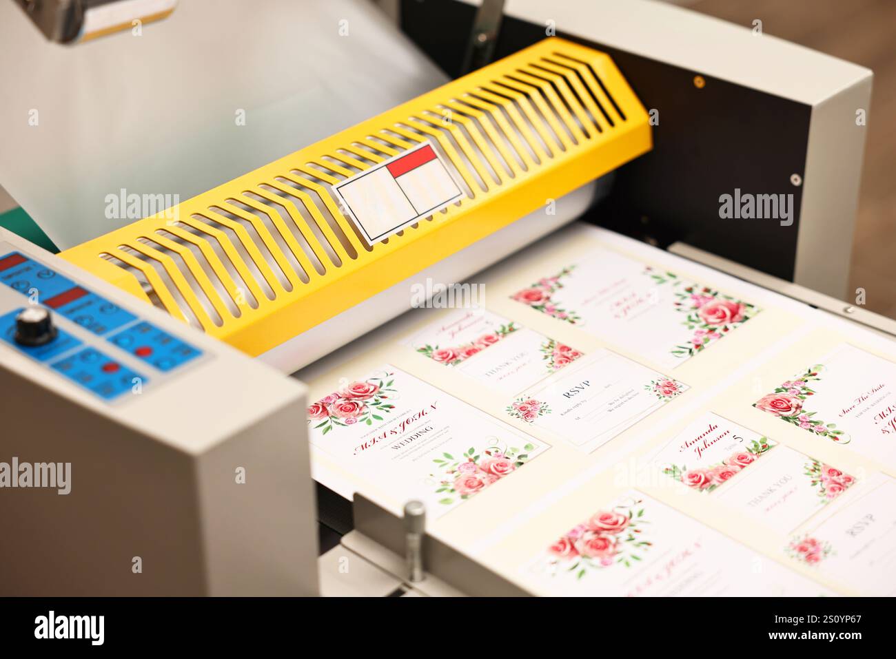 Modern roll laminator and paper sheet with invitation cards indoors ...