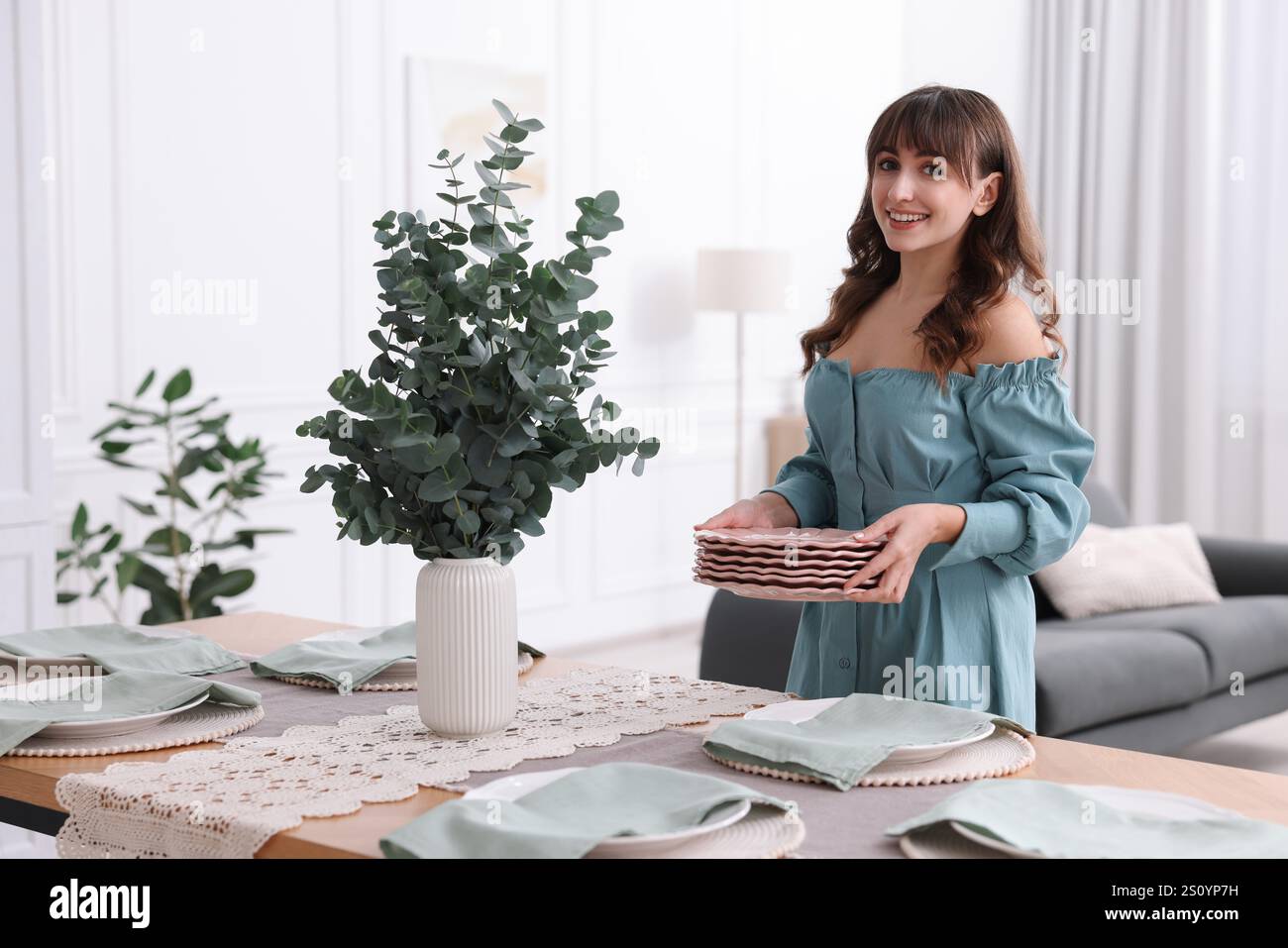 Woman setting table for dinner at home Stock Photo - Alamy