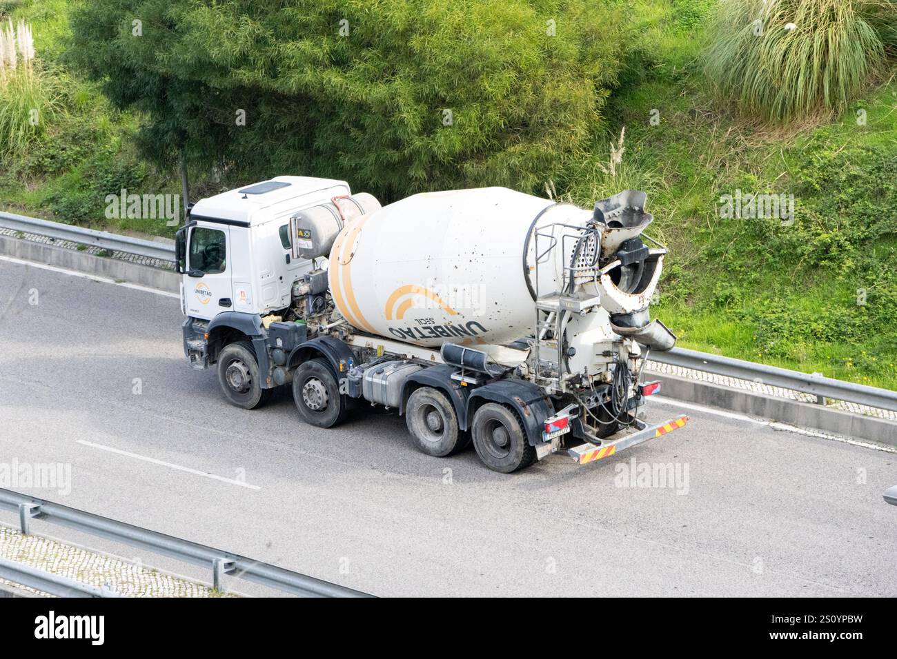 Cement mixer truck transporting concrete on the highway to construction ...