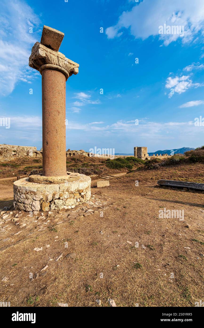 An ancient stone column at Methoni Fortress, surrounded by ruins and a ...
