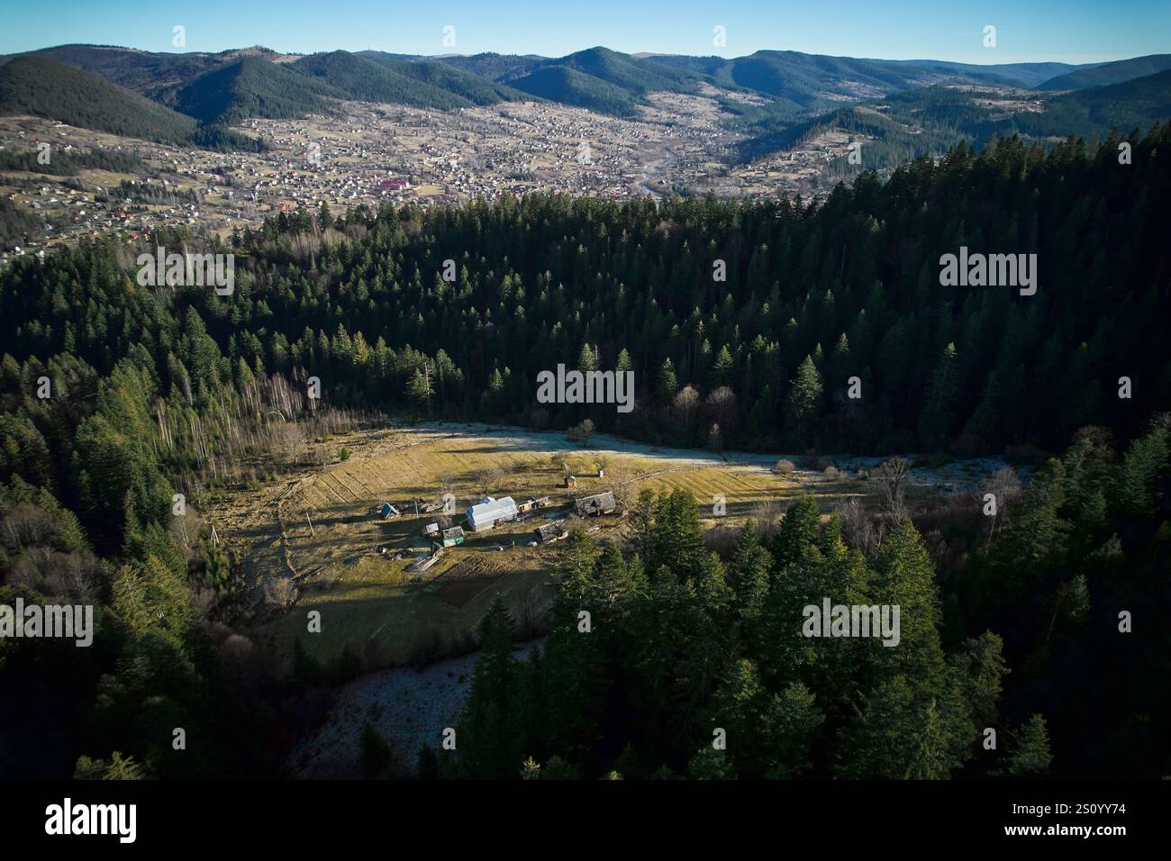Aerial view of rural farm nestled in clearing surrounded by dense ...