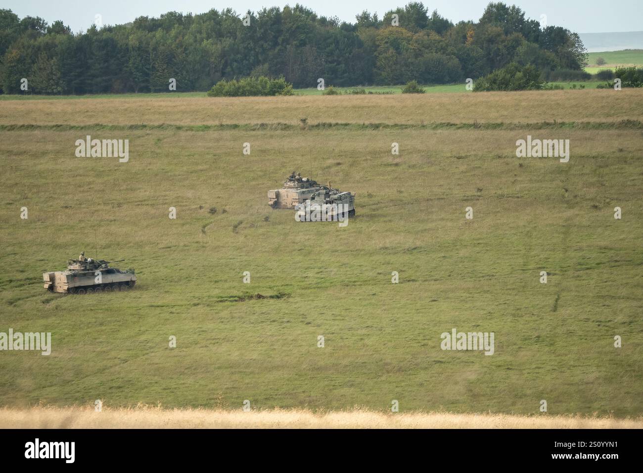 a squadron of British army Warrior FV510 IFVs in action on a military ...