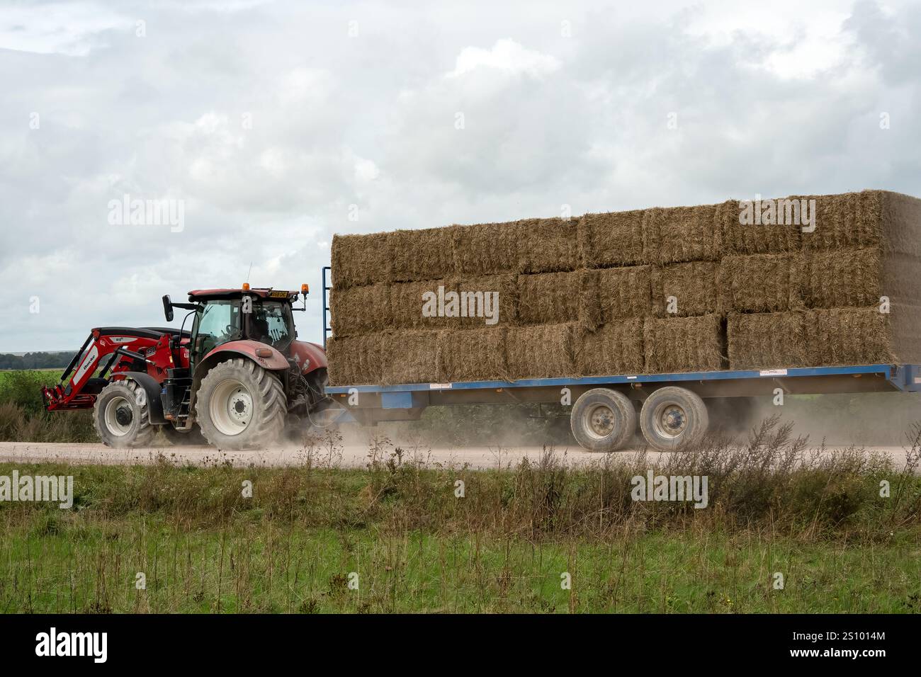 large red Case Puma 340 tractor towing a fully laden hay bale trailer ...