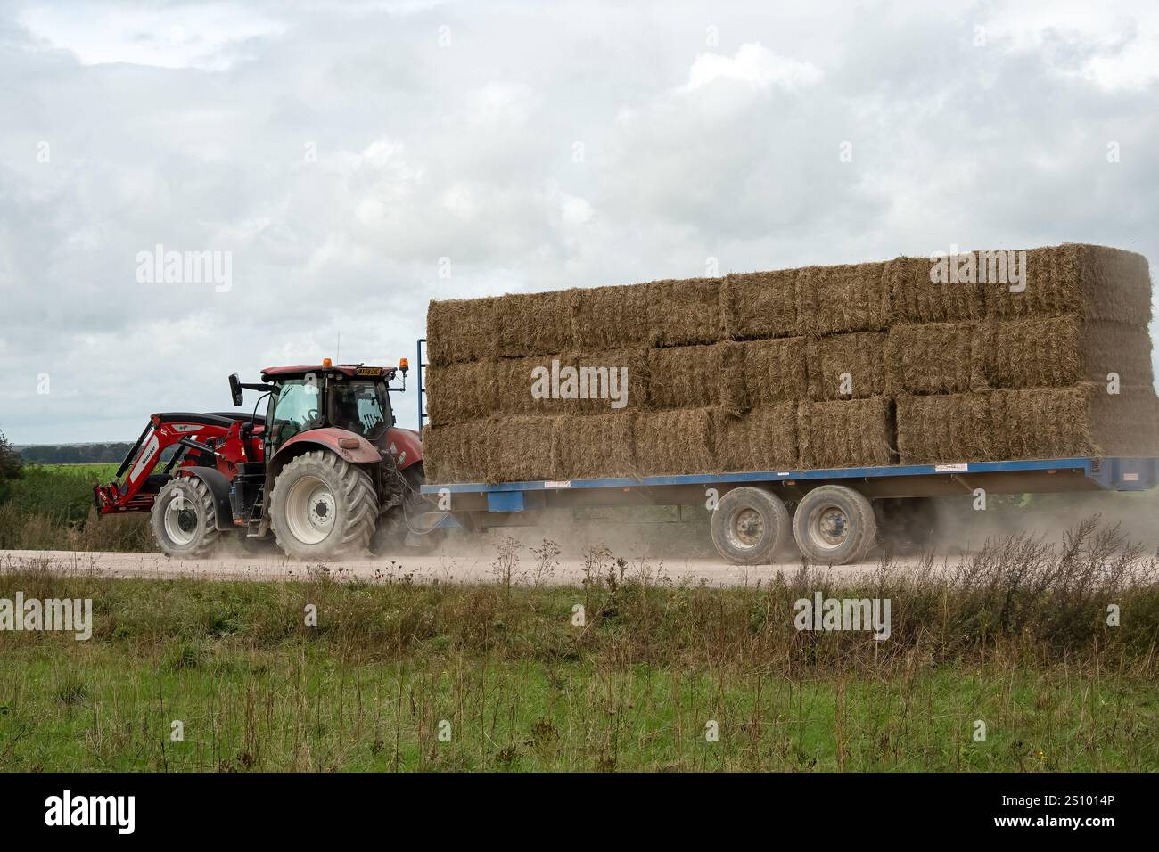 large red Case Puma 340 tractor towing a fully laden hay bale trailer ...