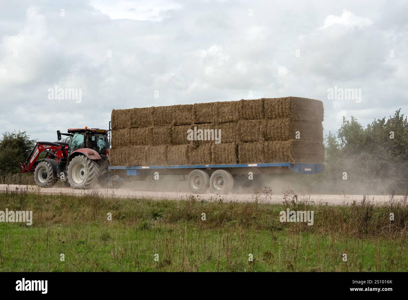 large red Case Puma 340 tractor towing a fully laden hay bale trailer ...