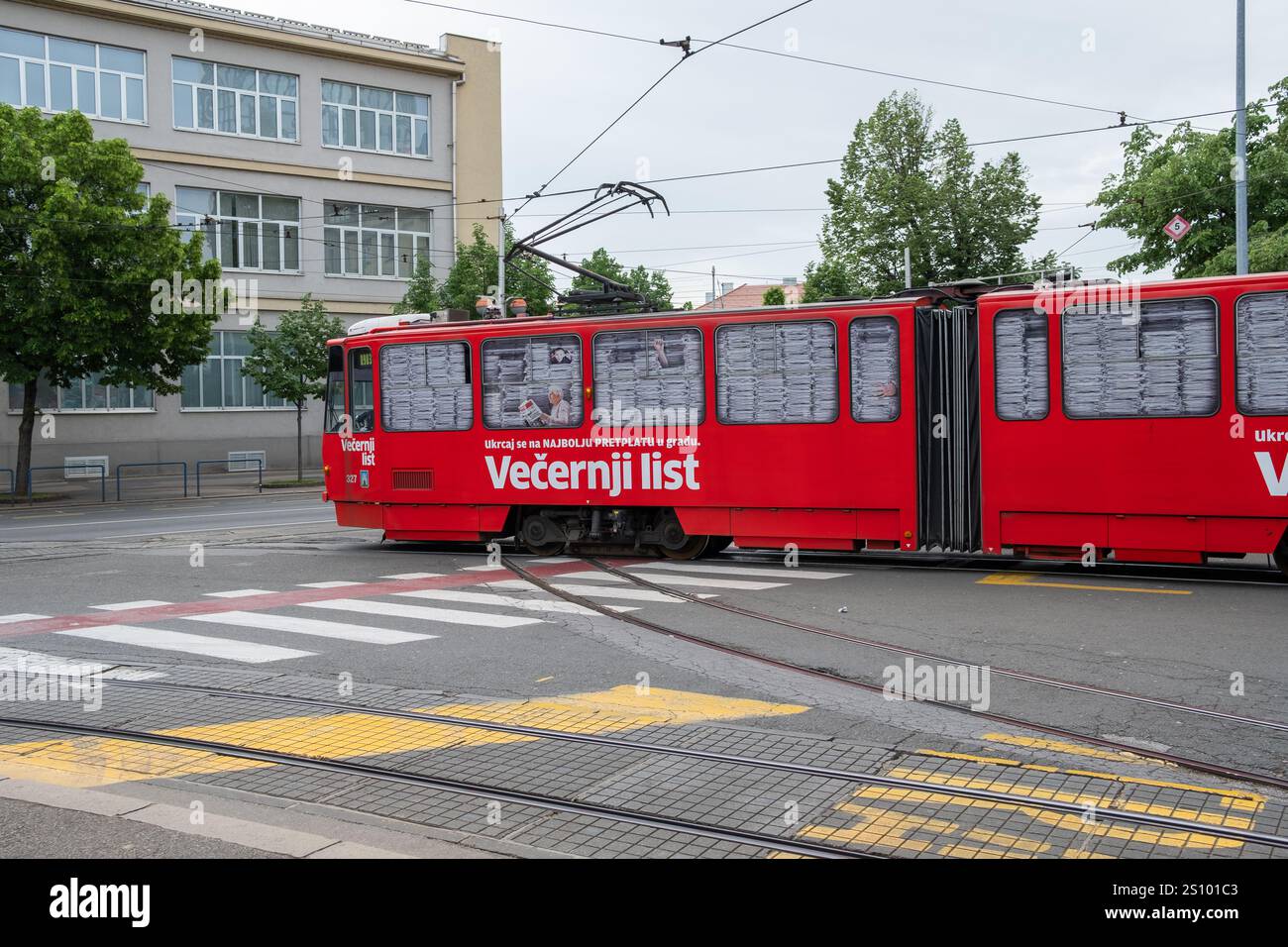Red tram in Zagreb with advertisement on carriage of evening paper with ...