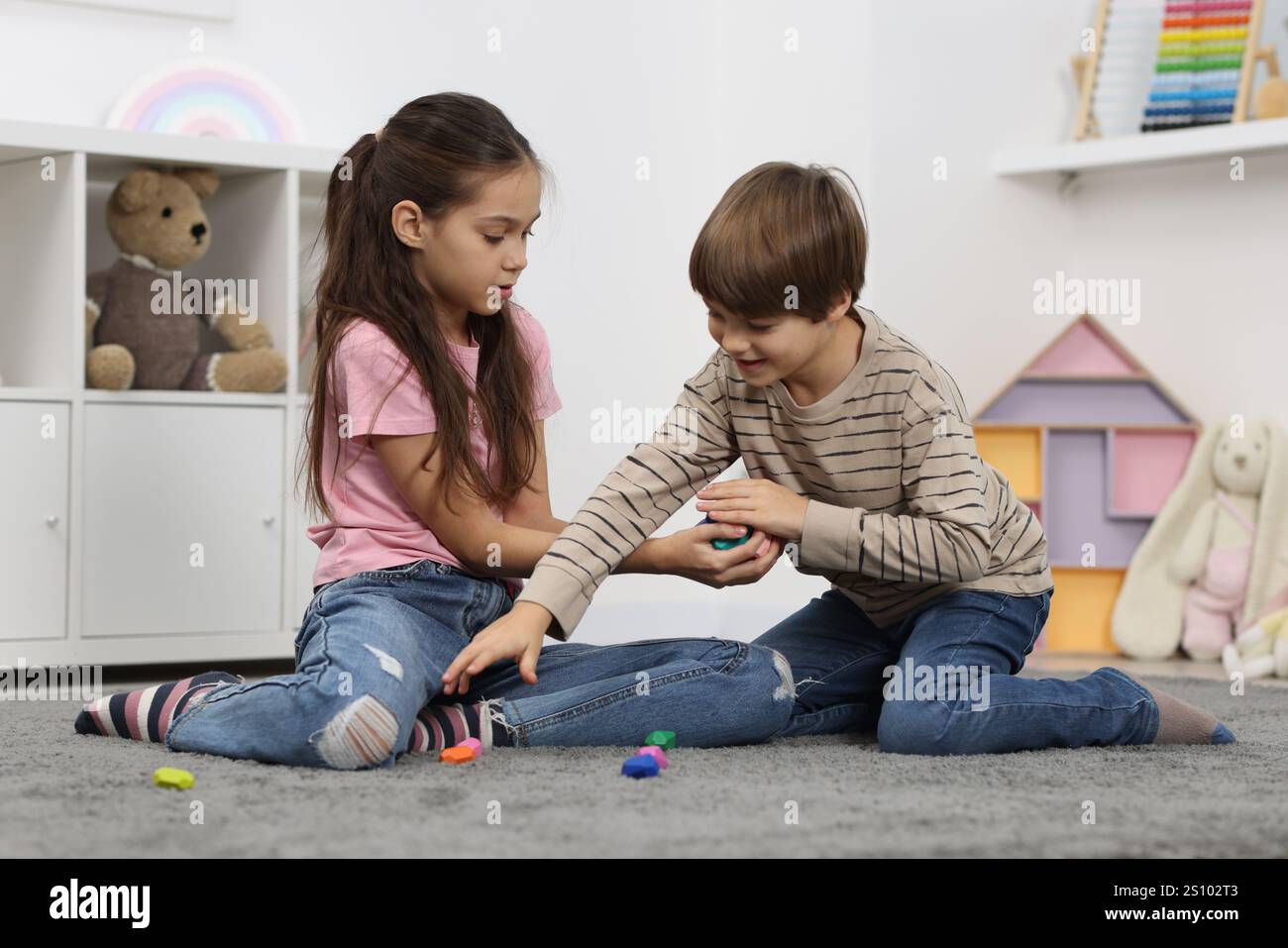 Children playing with balancing stones on floor indoors Stock Photo - Alamy