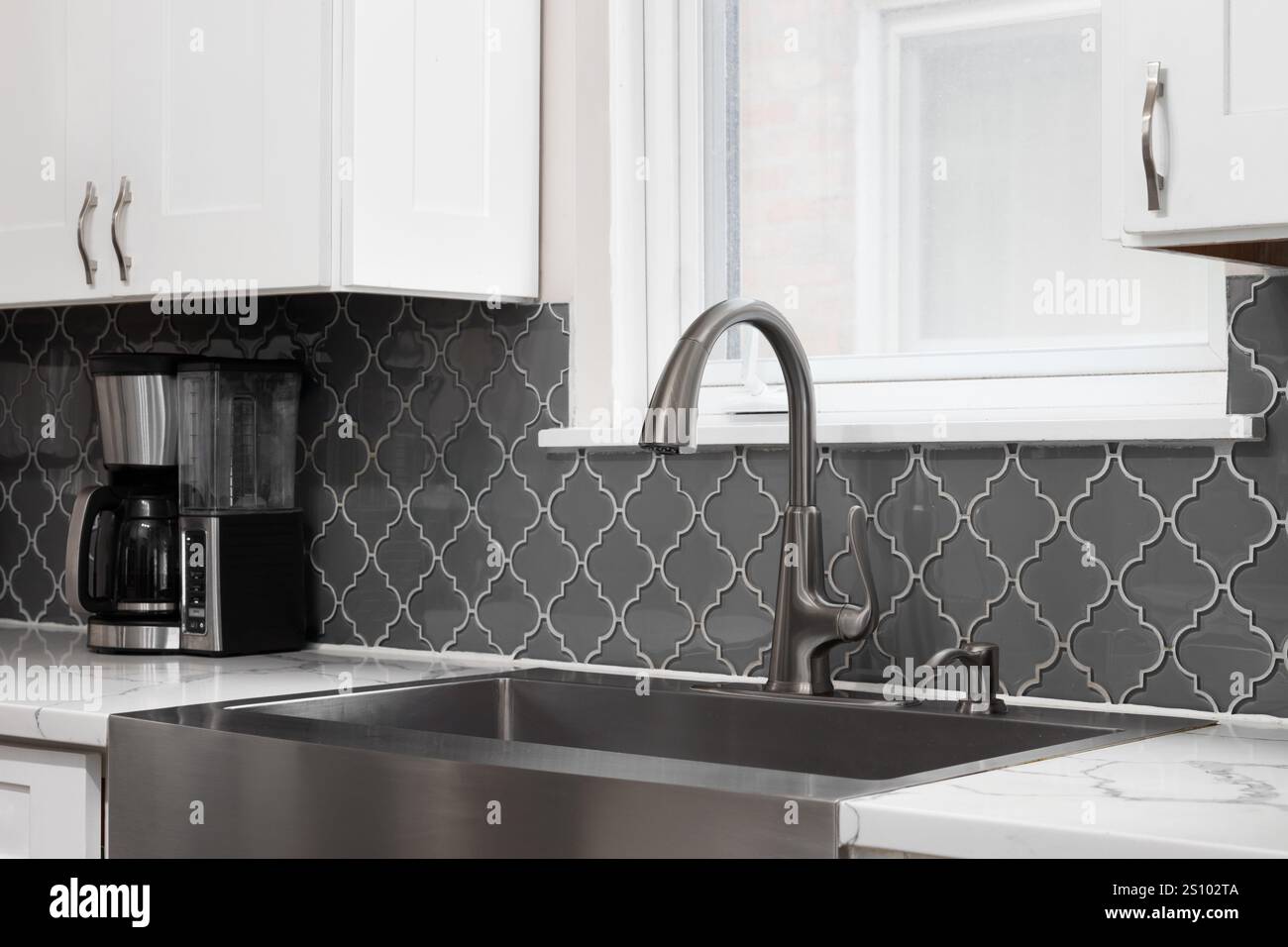 A kitchen faucet detail with a stainless steel apron sink, grey ...