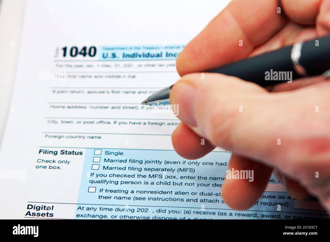 Male hand filling out writing 1040 tax form Stock Photo - Alamy