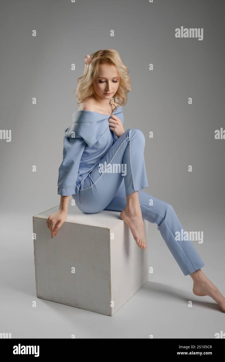 Model poses gracefully in light blue outfit on a minimalistic cube ...