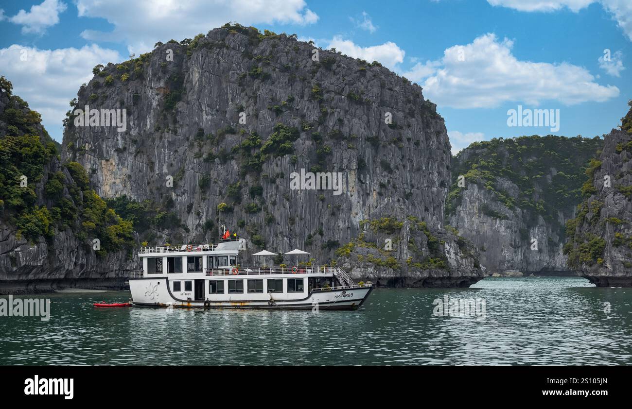 Cruise boat sailing among the rocks of Cat Ba island. A tour boat with ...