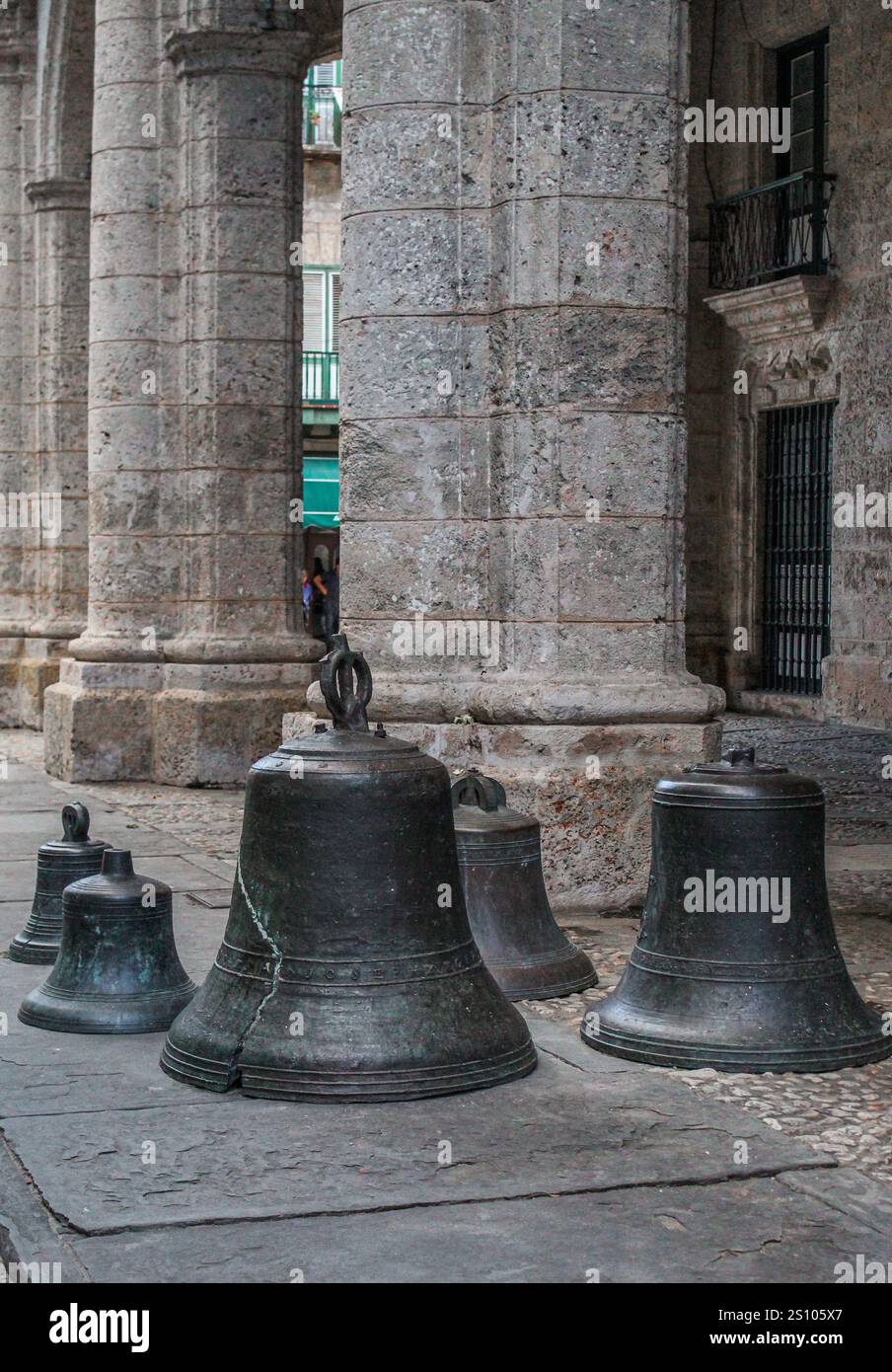 Havana's Iron Echoes: Five Bells Resting on the Street Stock Photo - Alamy