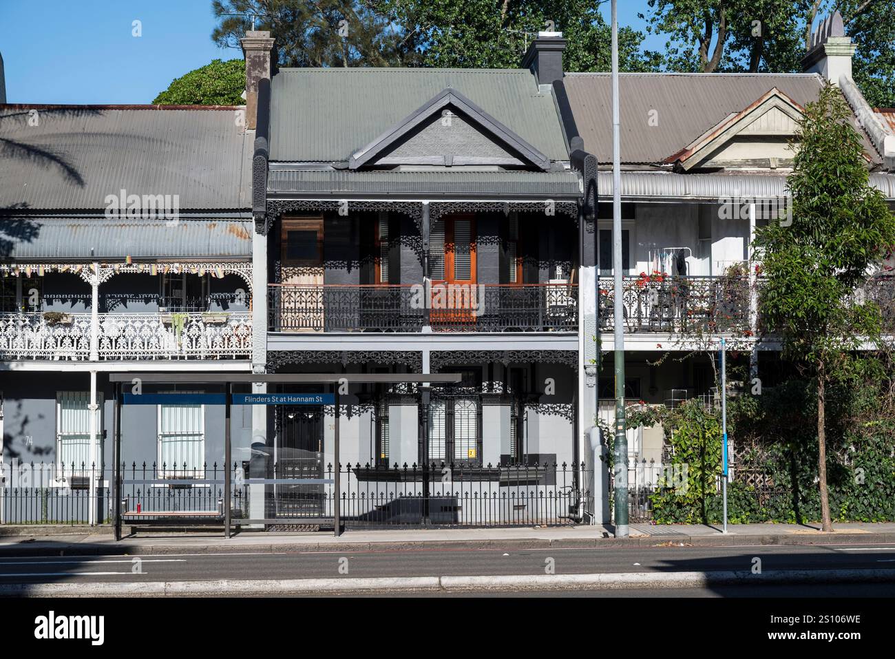 Street with Victorian-era houses adorned with ornamental iron lacework ...