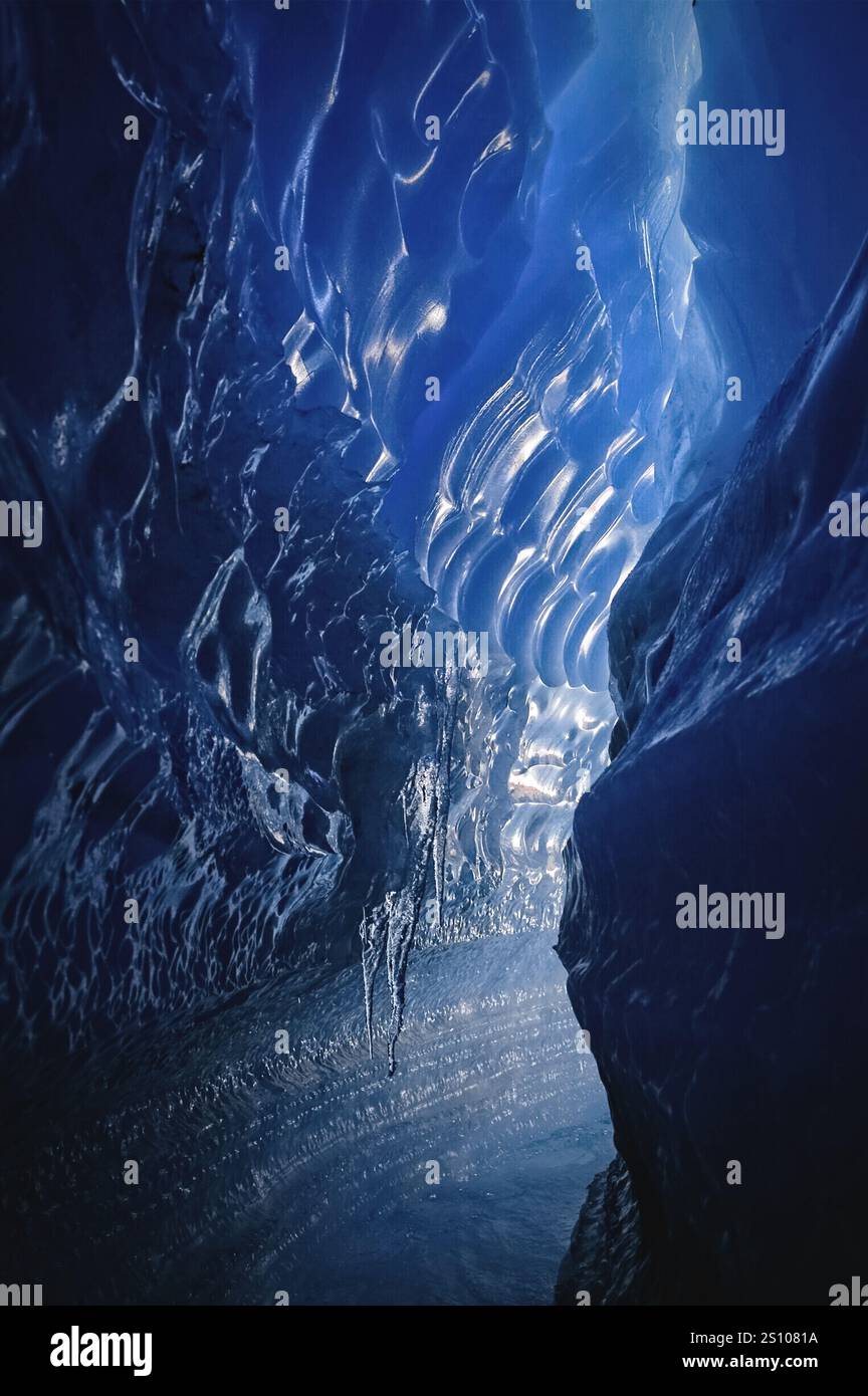 Ice cave in Antarctica. Blue cave with ice formations and a small ...