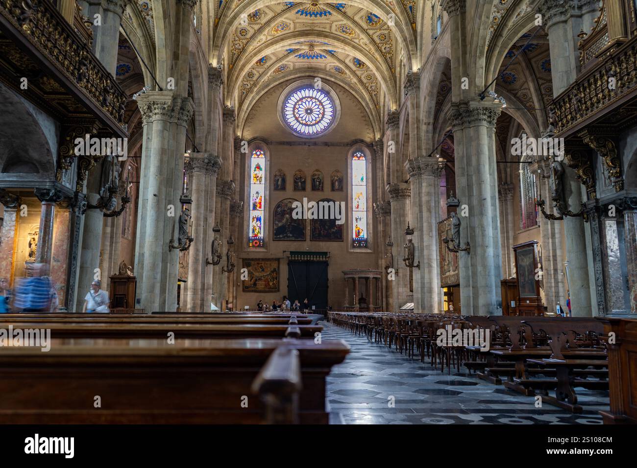 Interior of a grand cathedral with soaring stone columns, stained-glass windows, and intricate ...