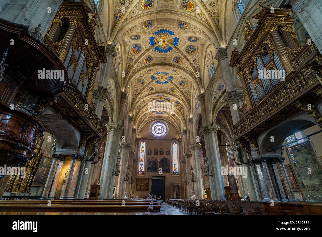Interior of a grand cathedral with soaring stone columns, stained-glass windows, and intricate ...