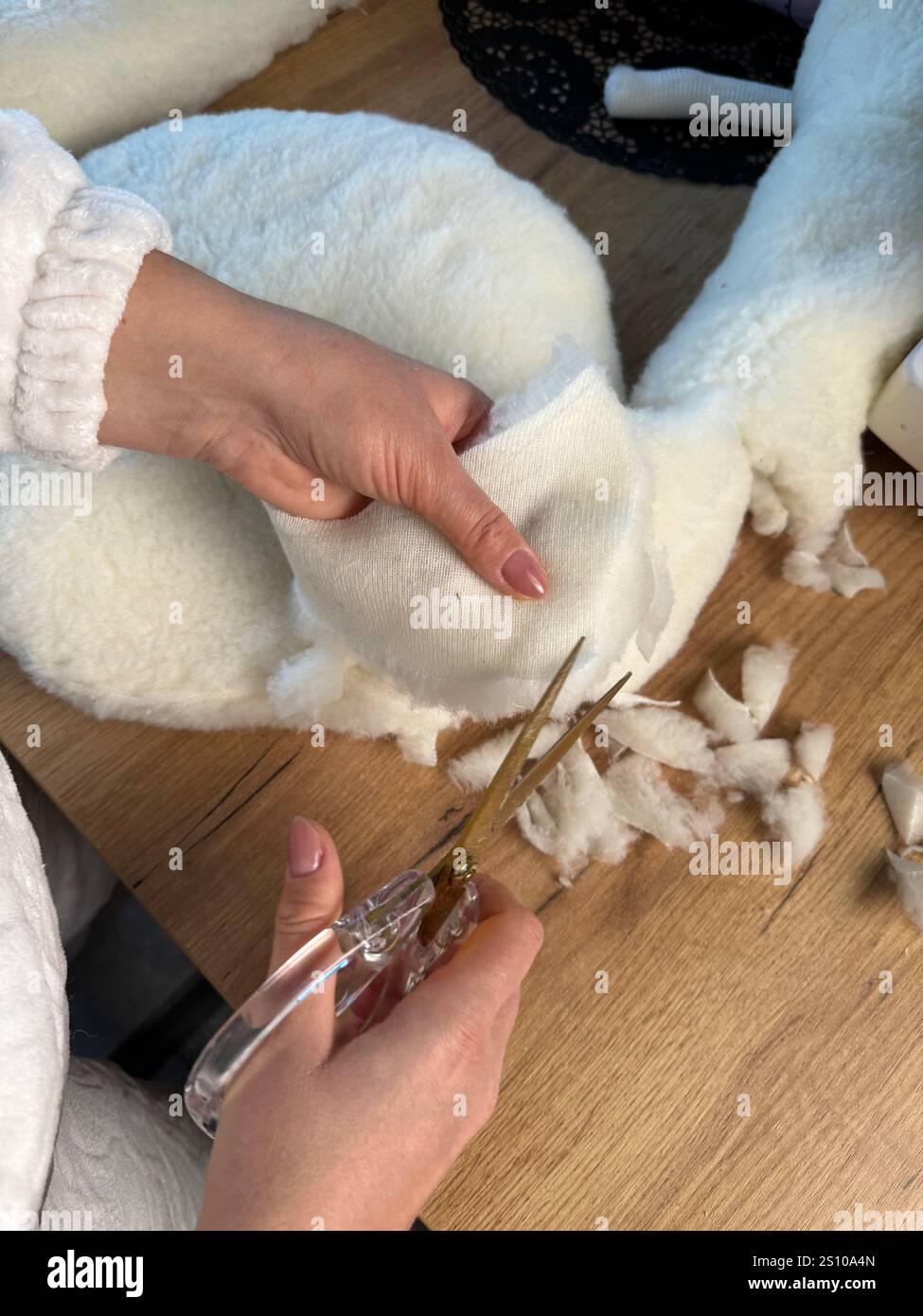 A woman is making a soft filler from fabric scraps. Cutting fabric ...