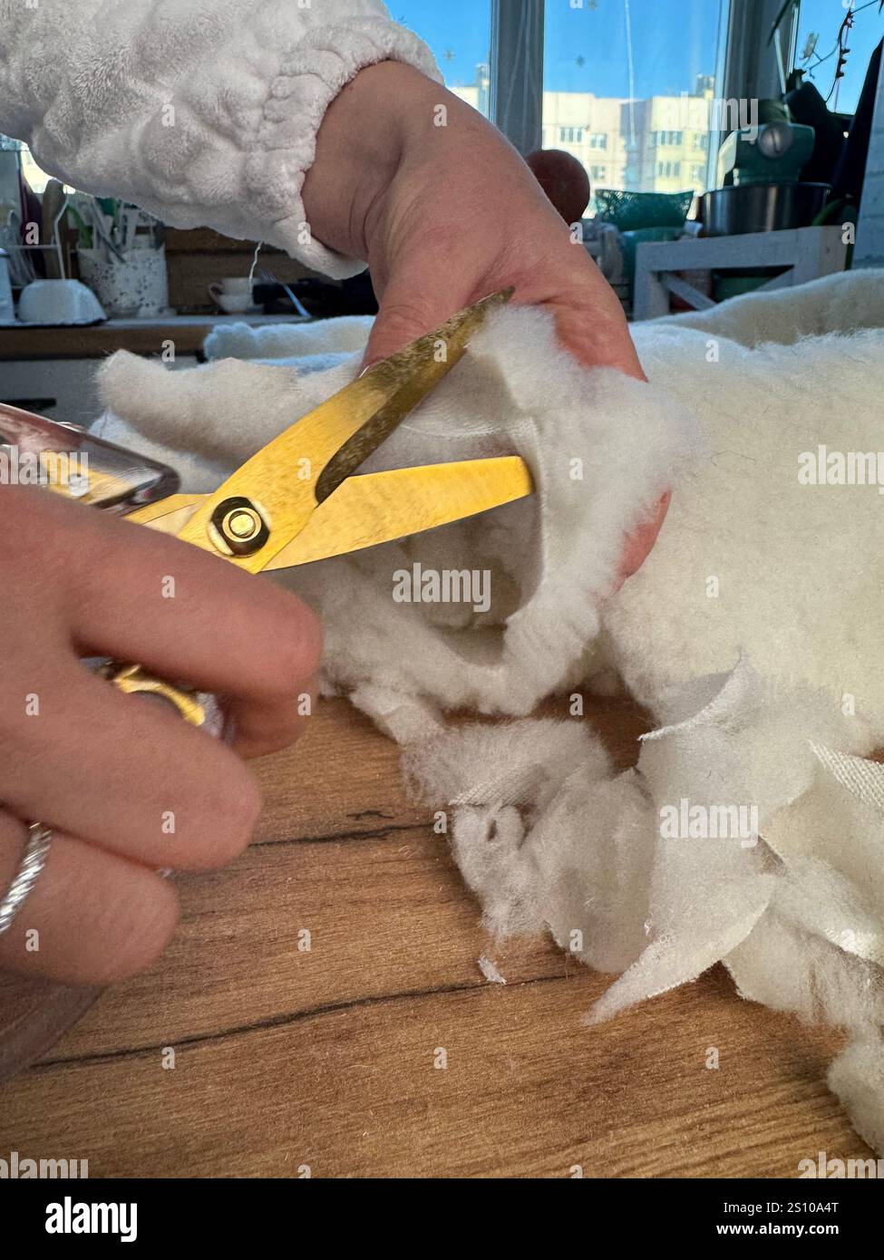 A woman is making a soft filler from fabric scraps. Cutting fabric ...