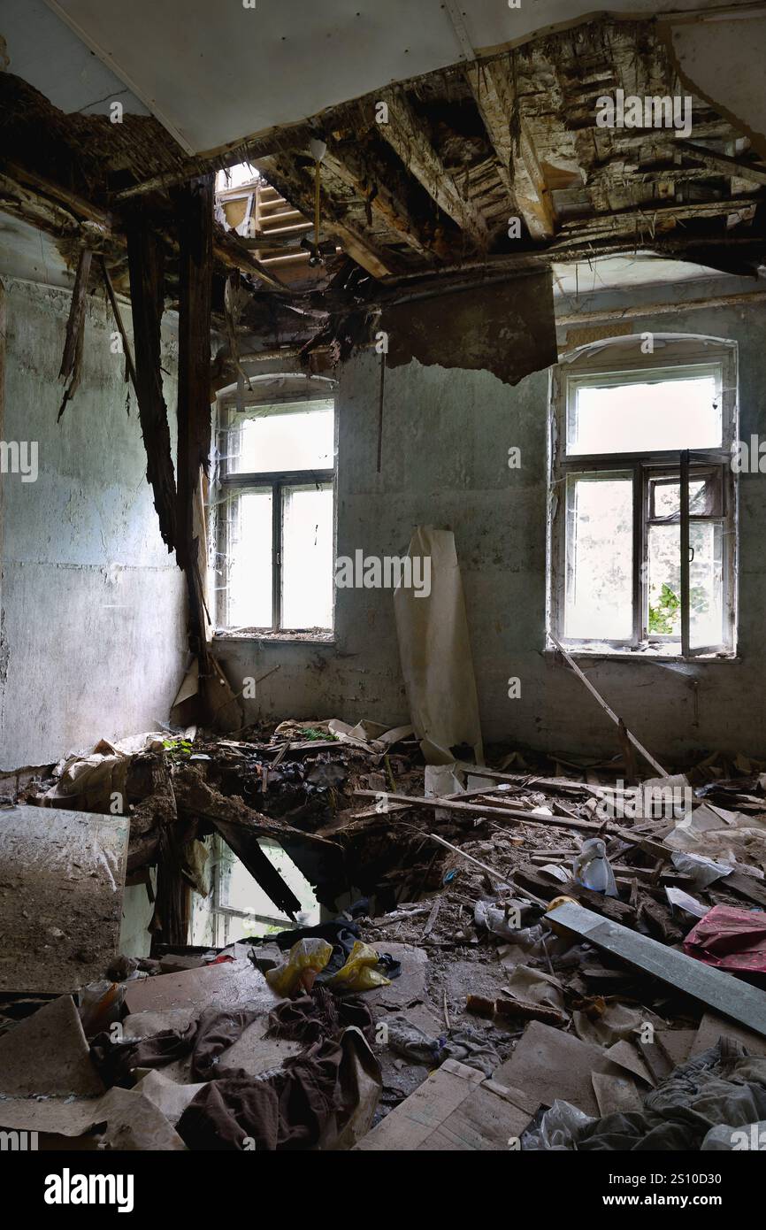 Interior of a living room with a collapsed ceiling and floor in an old ...