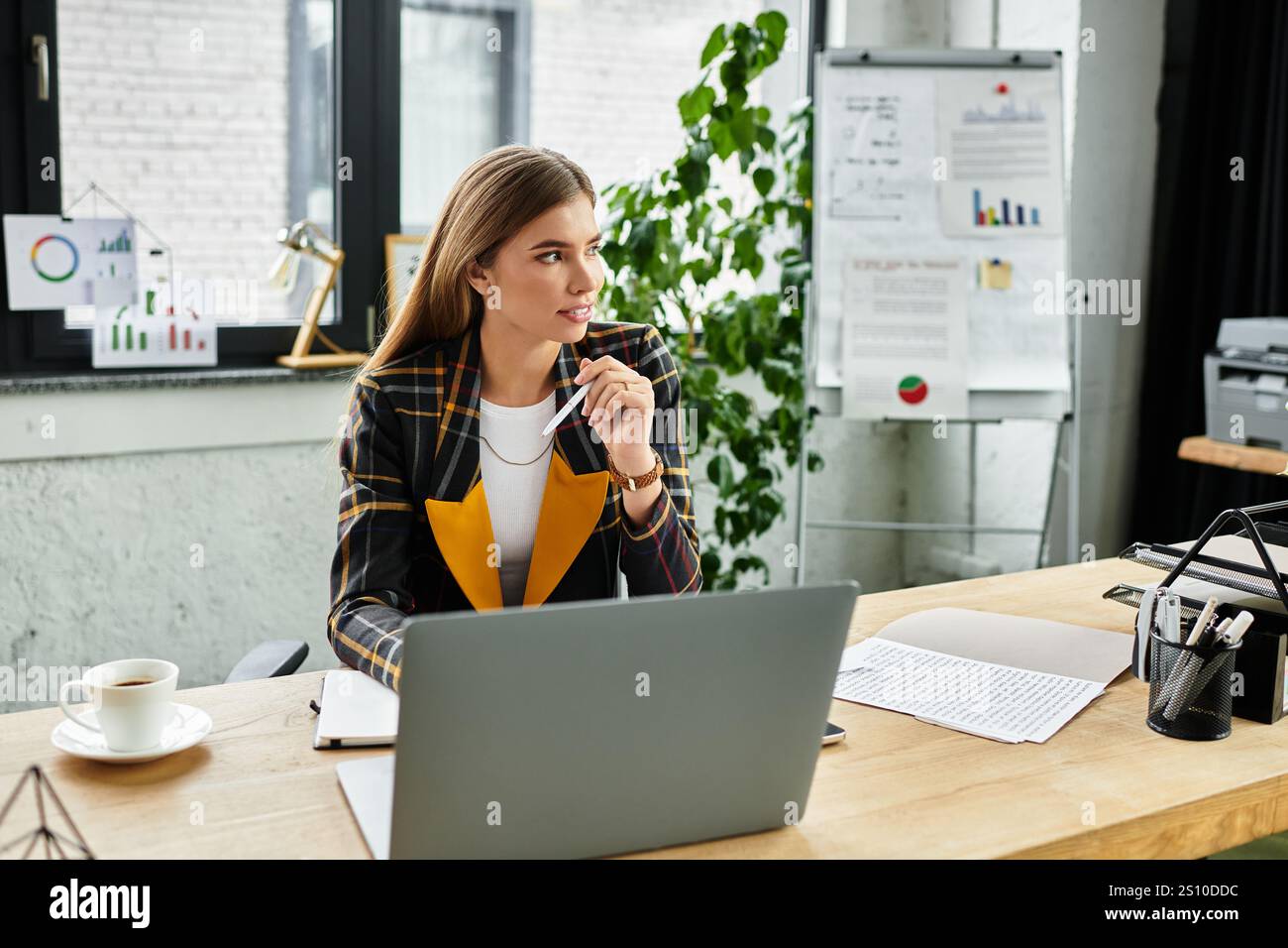 Stylish businesswoman focused on her tasks at a modern office workspace ...