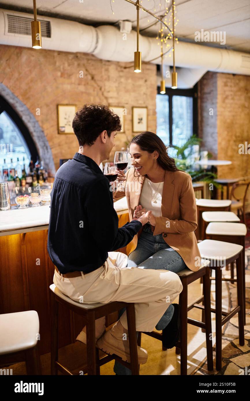 Couple enjoys an intimate moment, sharing laughter and wine at a ...