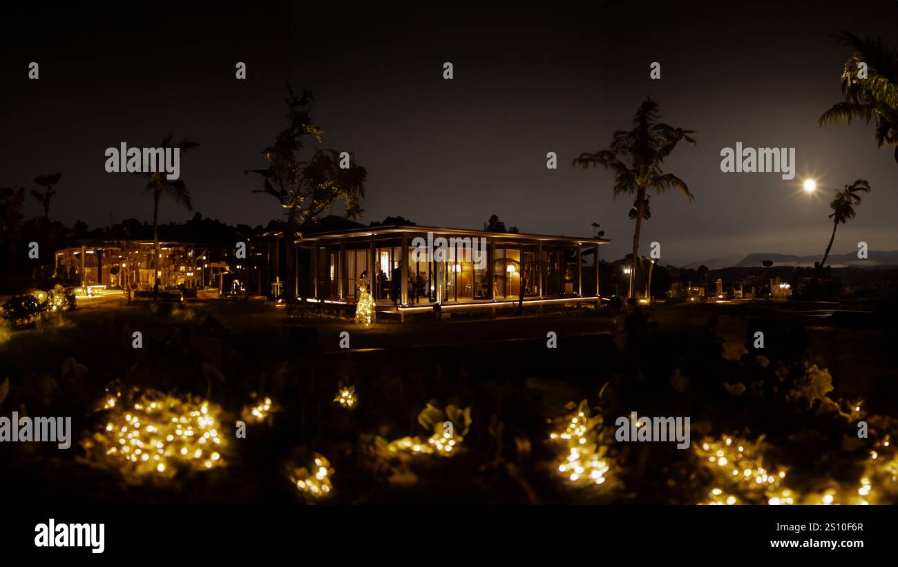 Tropical resort at night with illuminated bungalows and palm trees ...