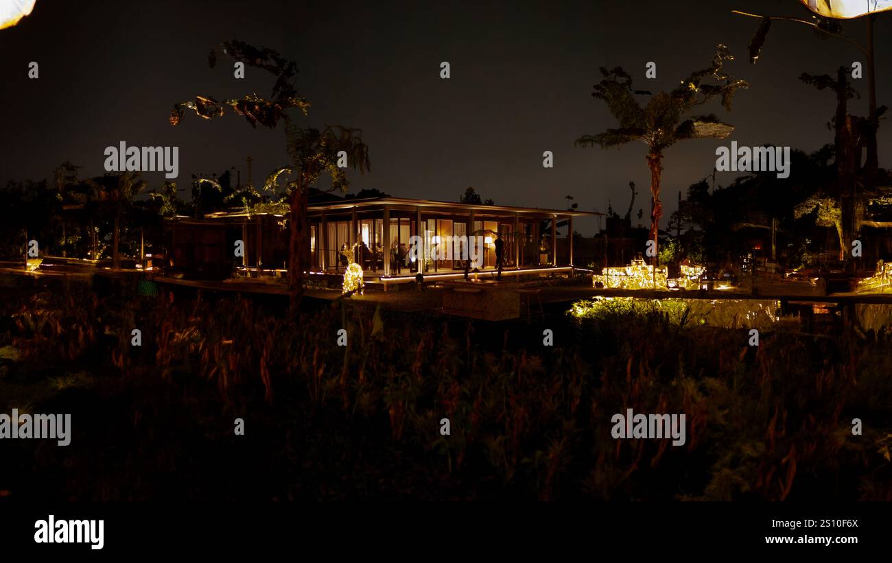 Tropical resort villa at night with illuminated interior, surrounded by ...