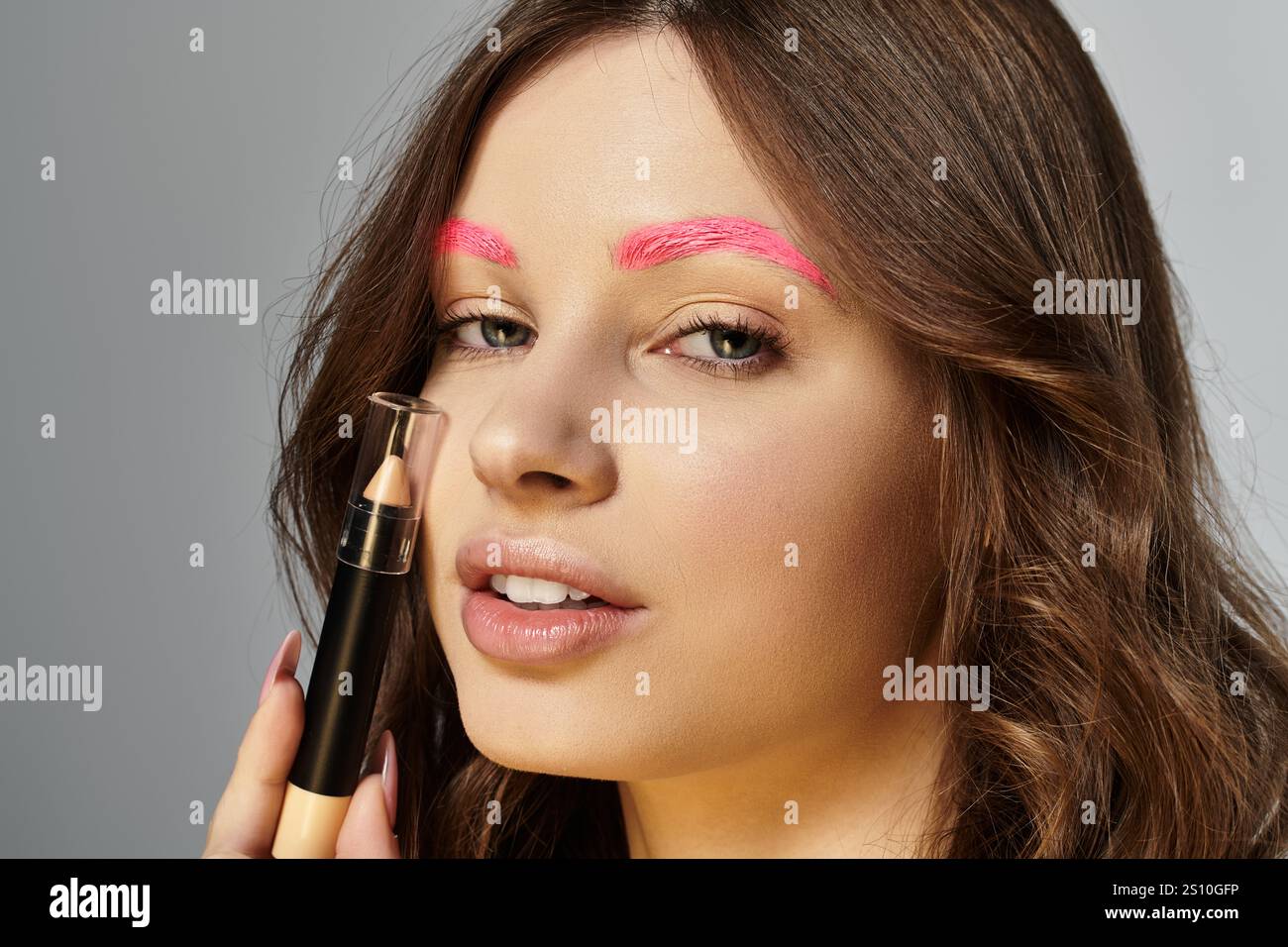 Attractive young woman showcases her striking pink eyebrows and unique beauty in studio Stock ...