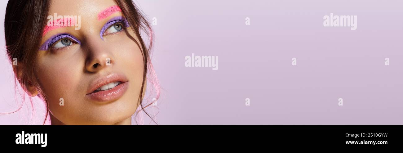 A young woman displays her beauty with bold purple eyeshadow and pink ...
