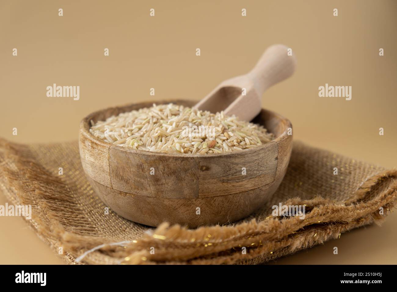 Brown rice in neutral beige background copy space. Whole spelt grain ...