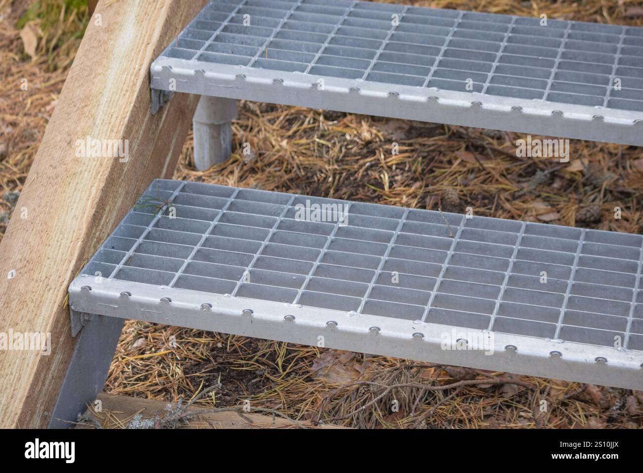 The picture shows two metal ladder steps attached to a wooden frame ...