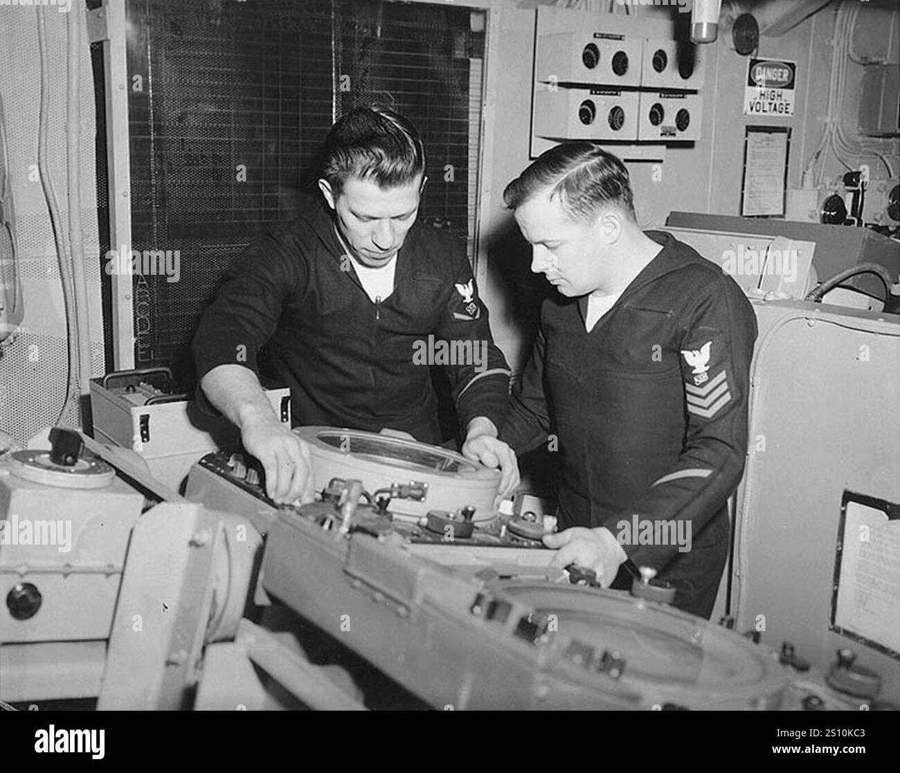 Electronics technicians working on equipment aboard USS Baltimore (CA ...