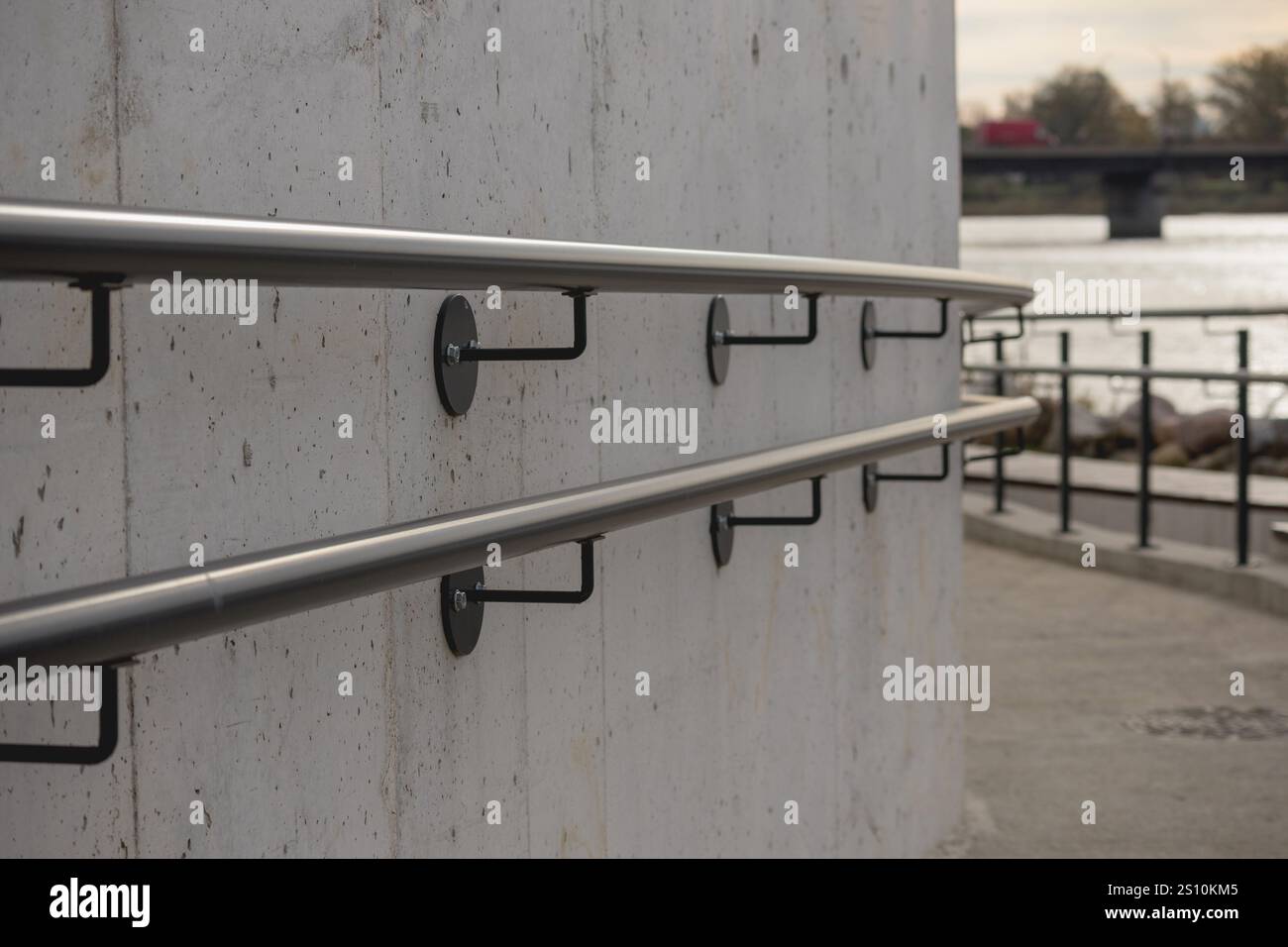 A fragment of a concrete wall with attached metal railings. The ...