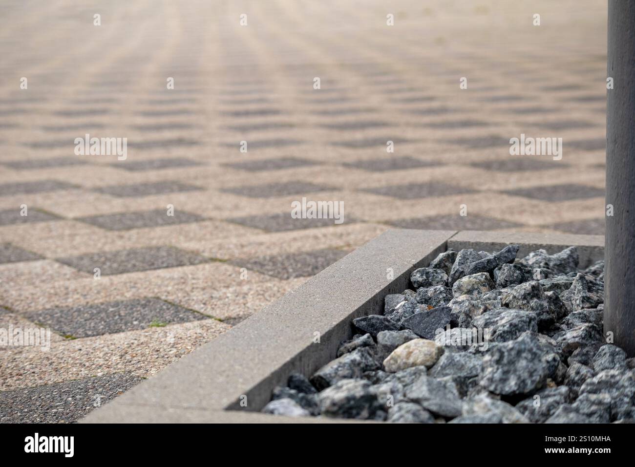 A pavement of small gray concrete blocks arranged in a checkerboard ...