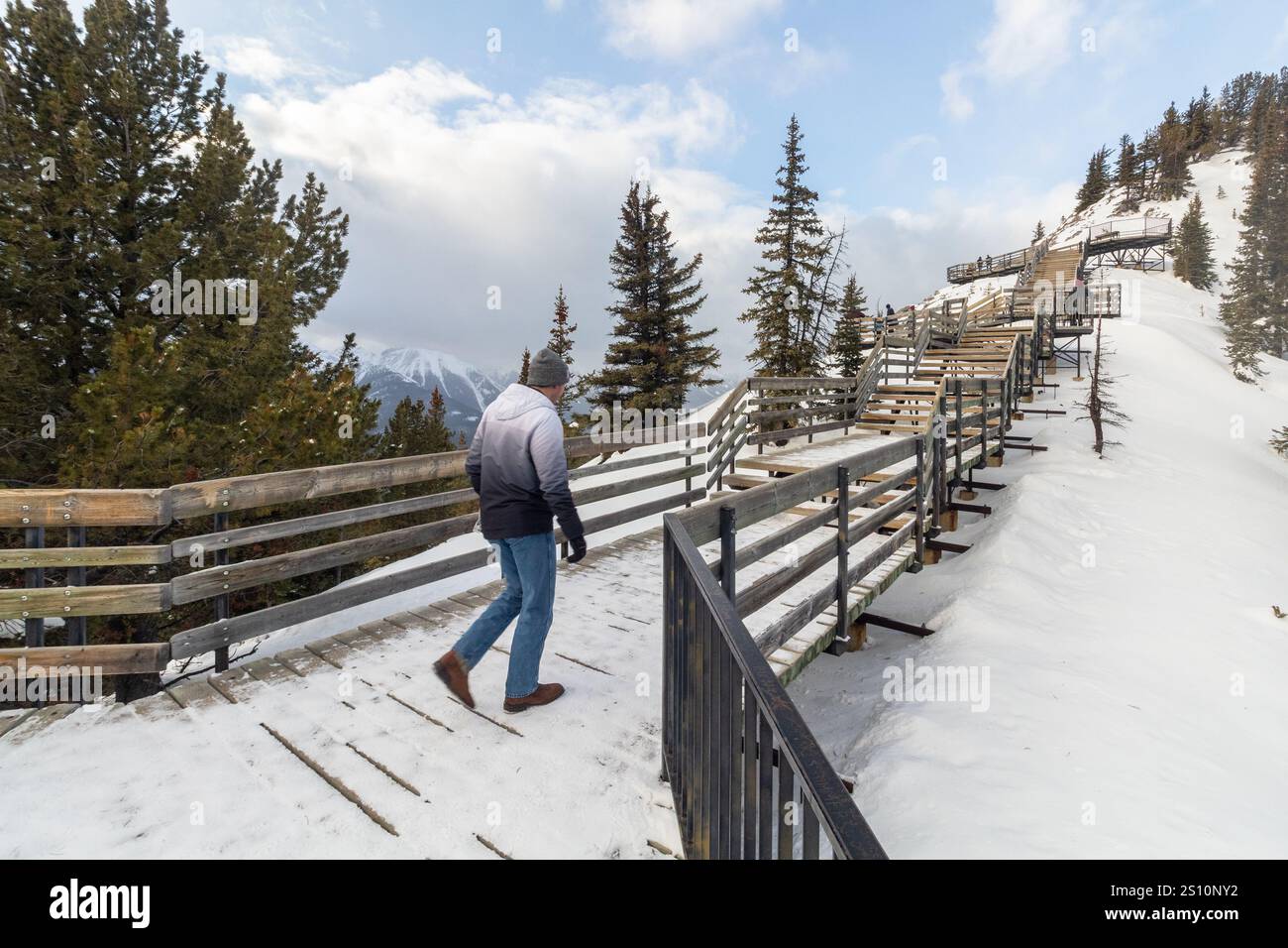 A tourist in winter clothes climbing the wooden stairs to the Sulphur ...