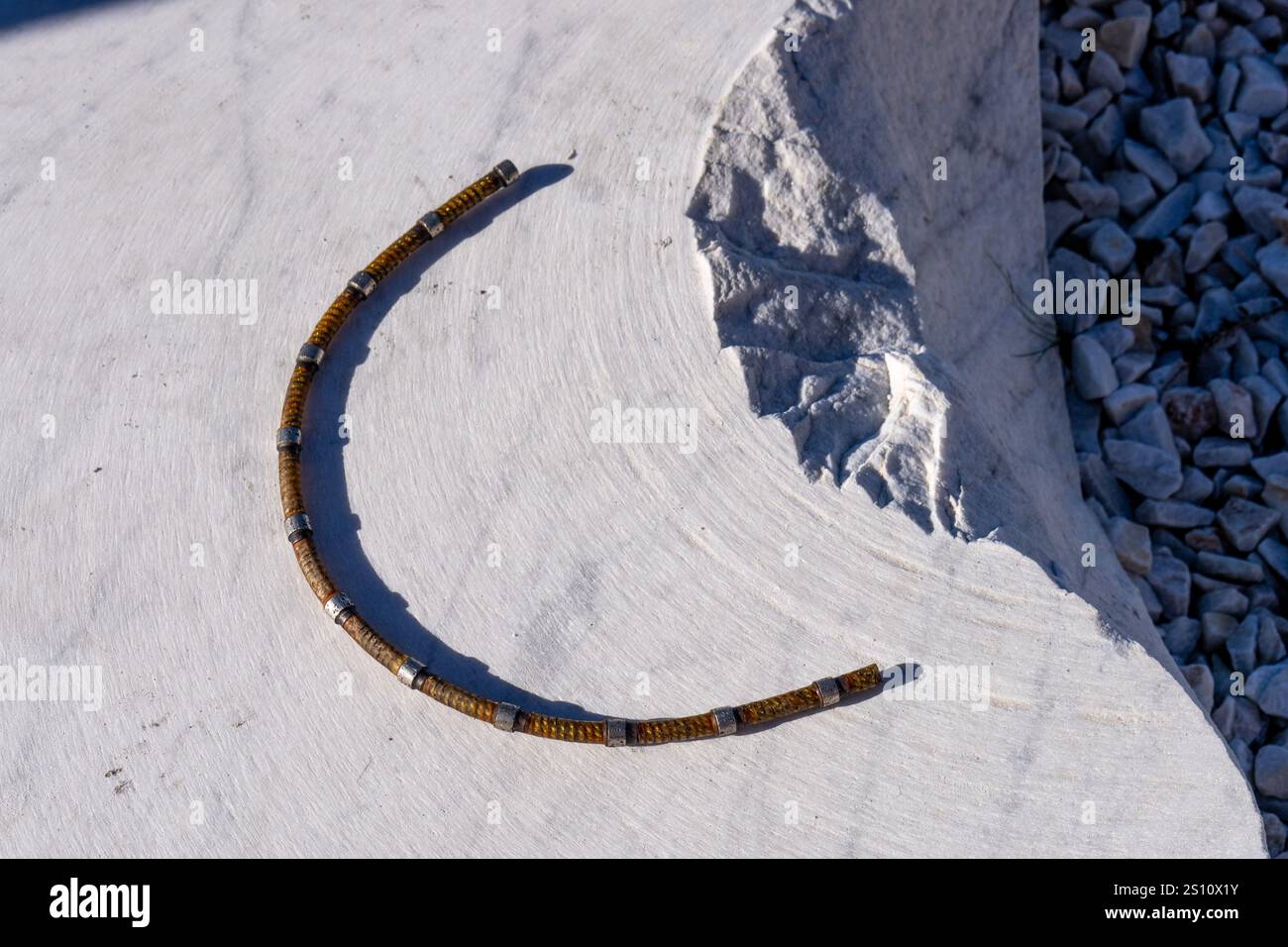 A segment of the diamond-coated wire used to cut blocks of marble from ...