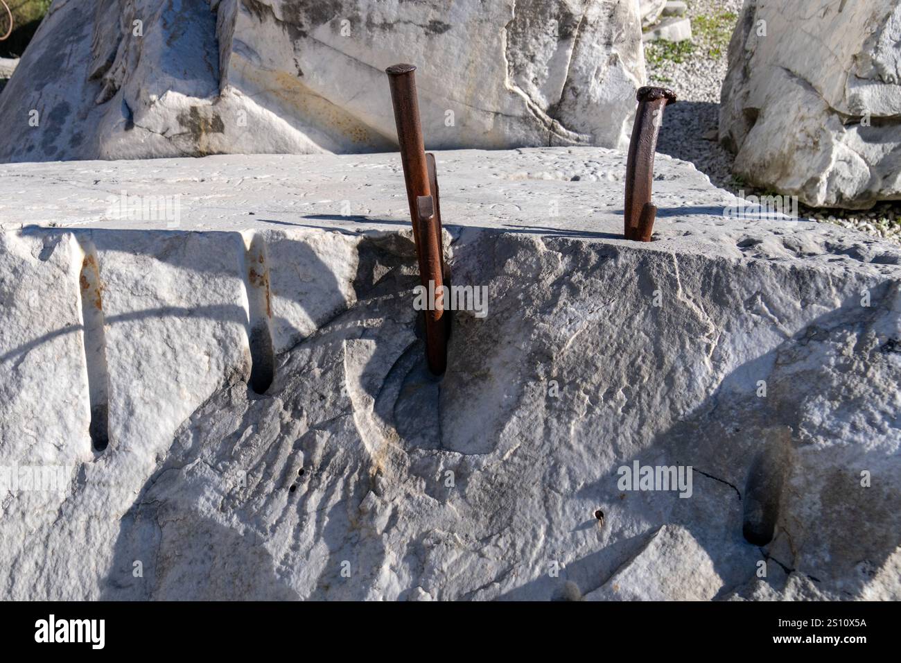 Hammer-driven steel wedges used to split marble blocks in a quarry ...