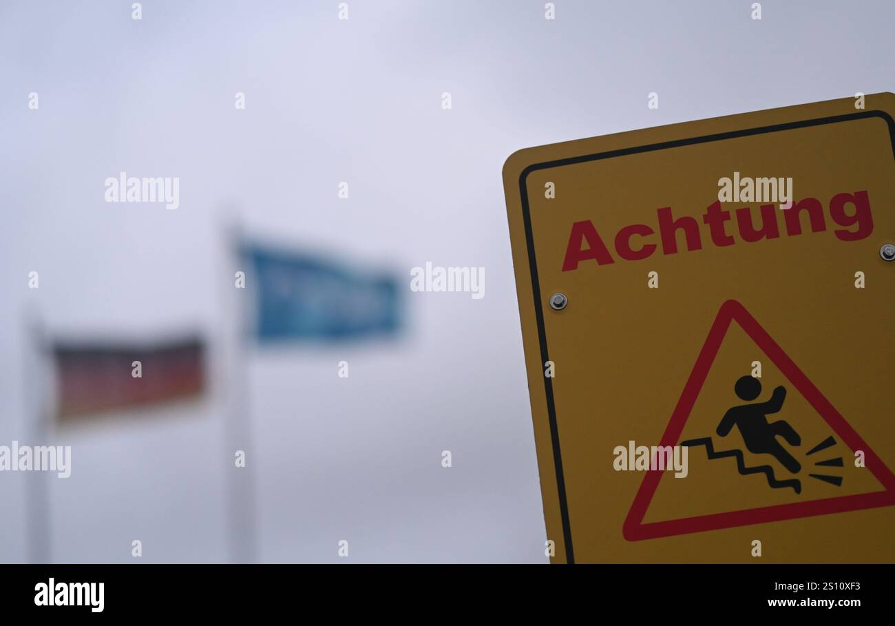 Leer, Germany. 30th Dec, 2024. A sign warns of the danger of falling ...