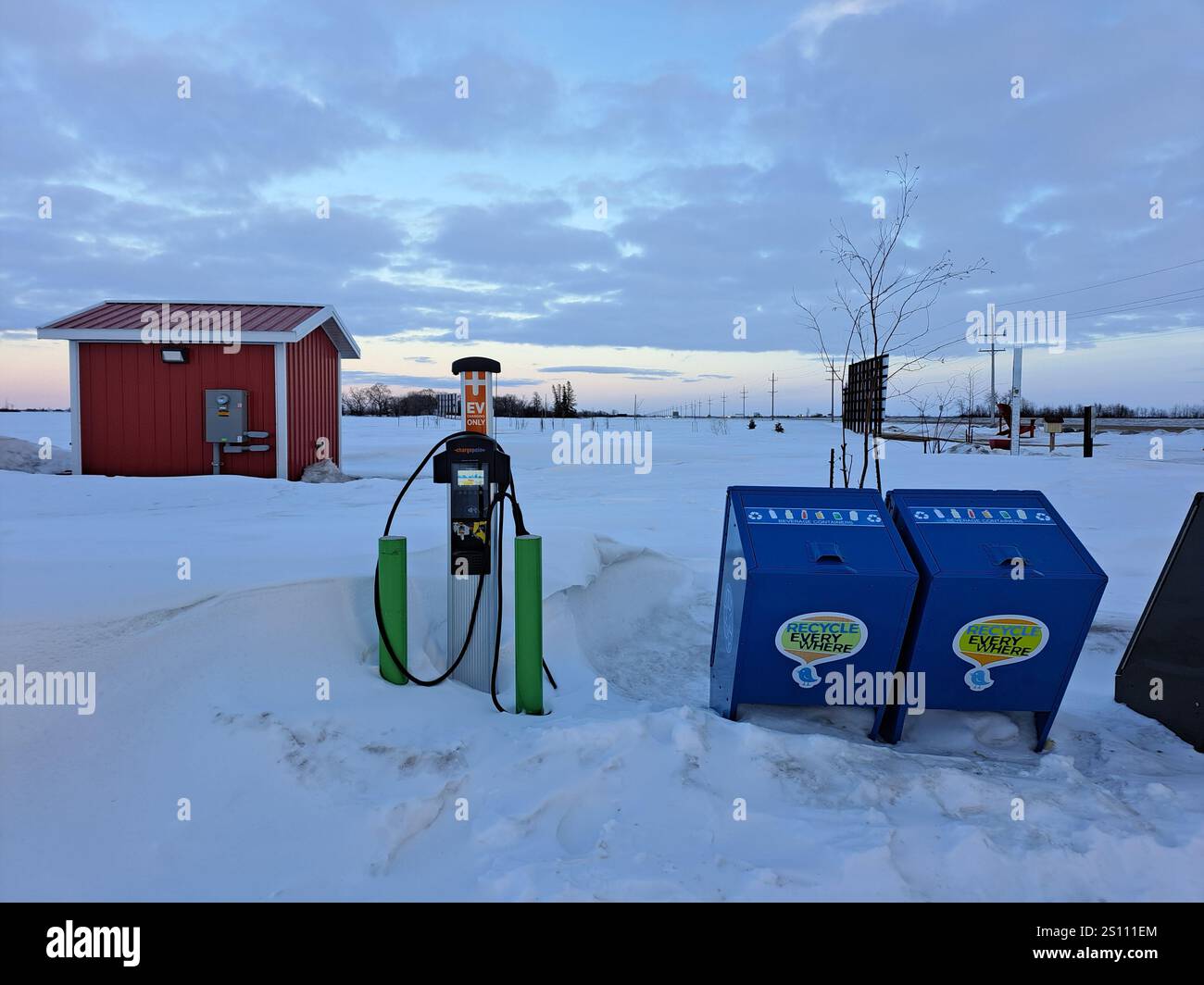 EV charger and blue recycling bins at the longitudinal centre of Canada ...